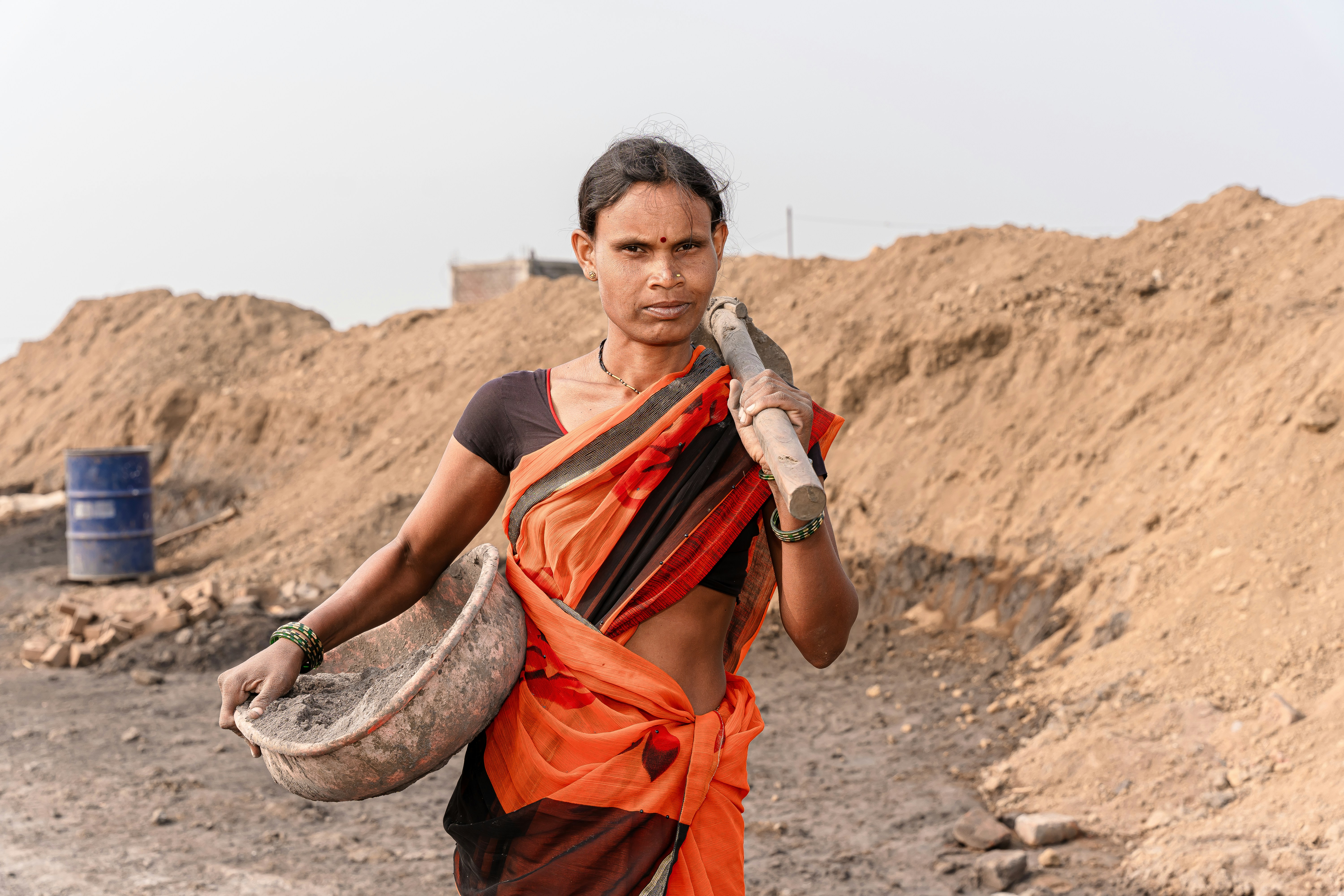 A woman in an orange and black sari carrying a snake photo – Free ...