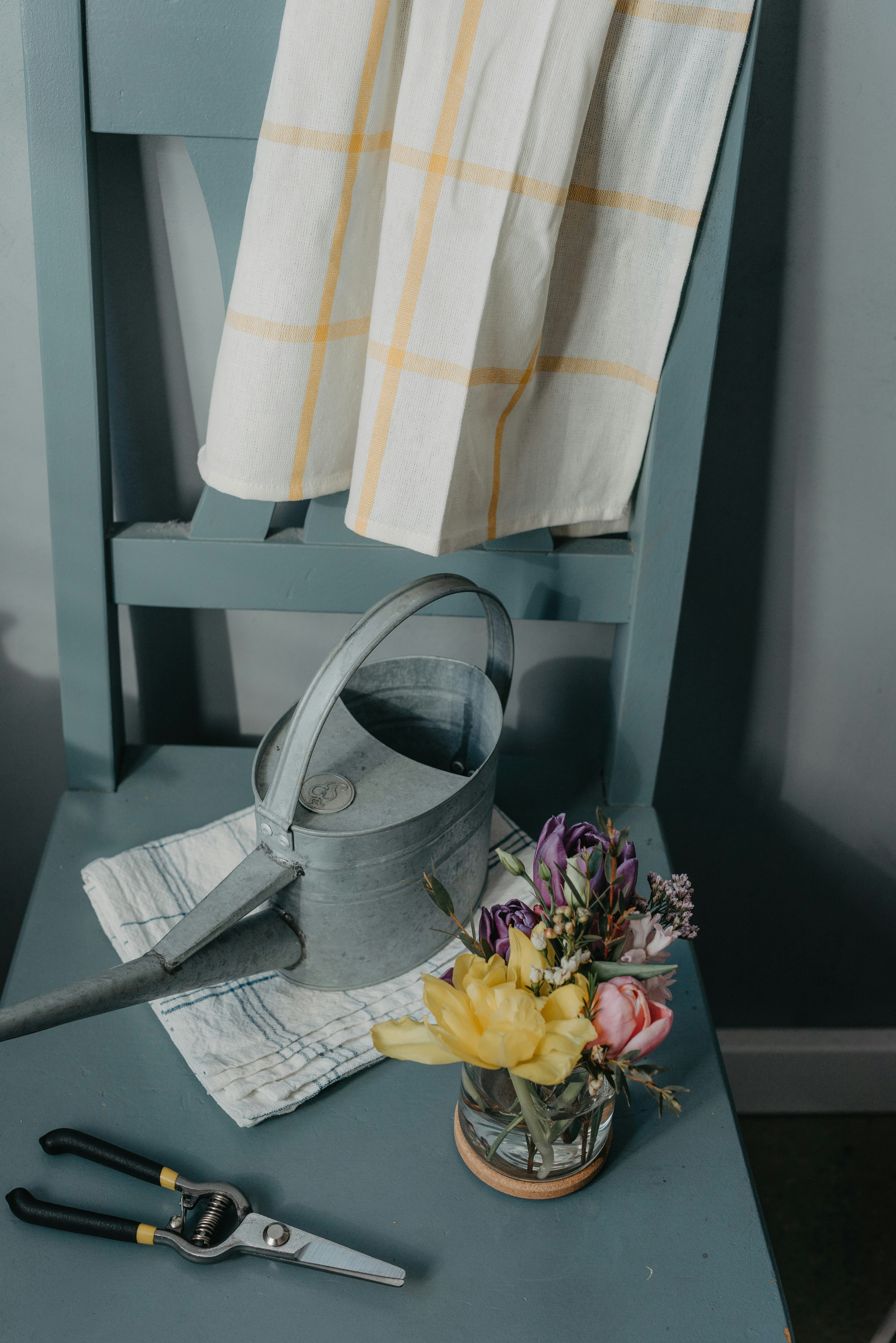 Blue-Accented Still-Life: A Metal Watering Can at Rest with Fresh Bouquet