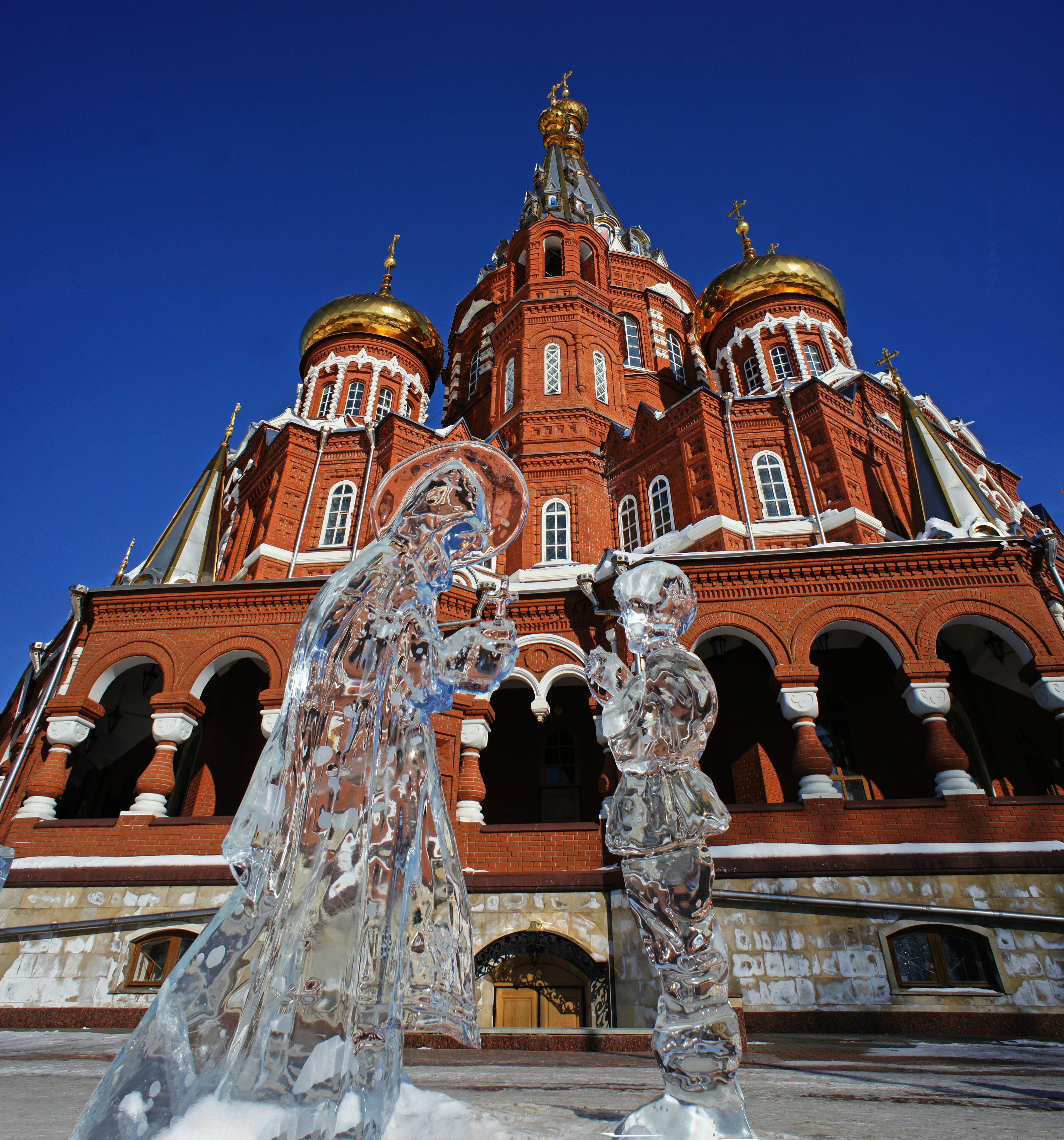 Ice Sculptures Framing a Red-Brick Cathedral with Golden Domes