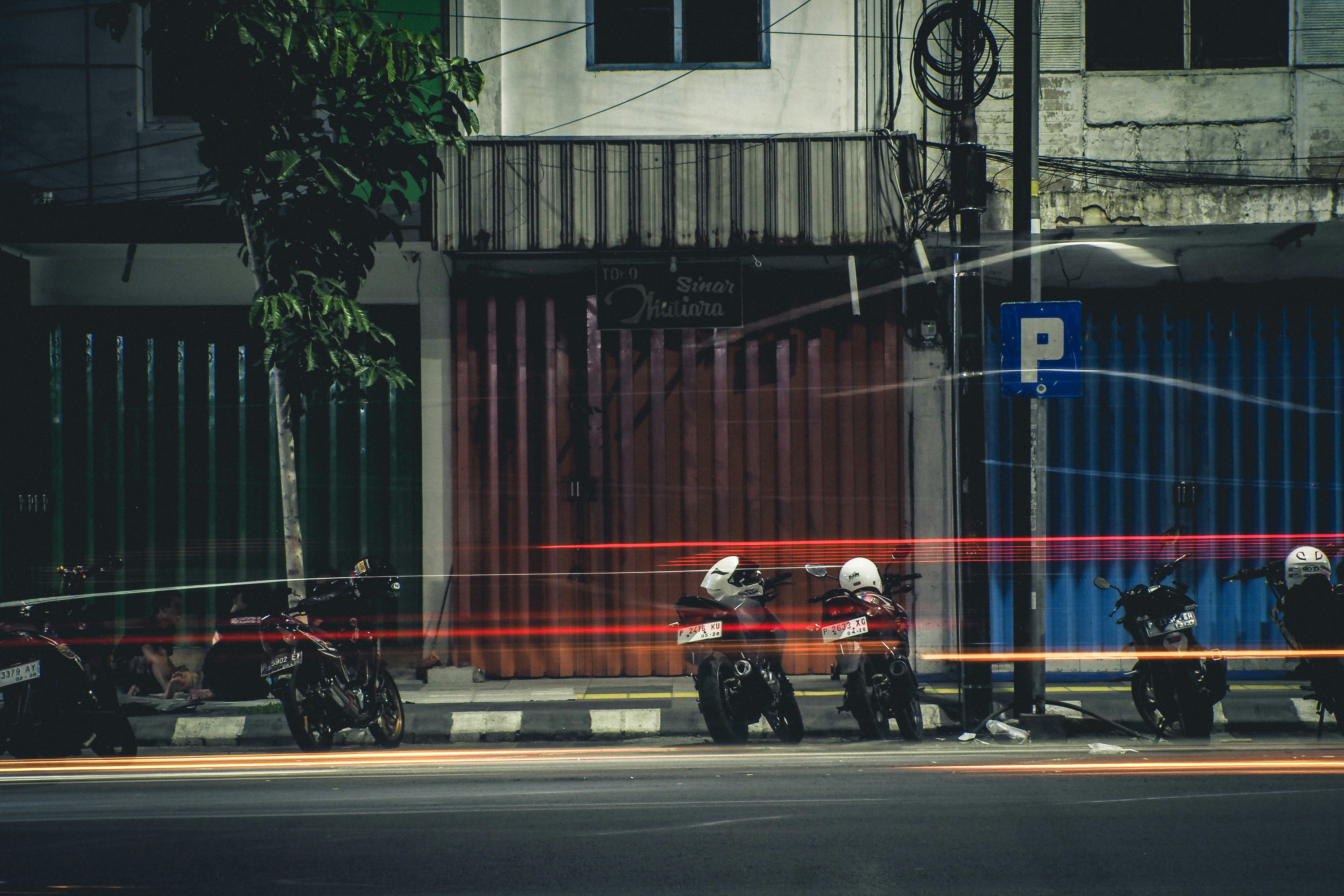 A group of people riding motorcycles down a street photo – Free ...