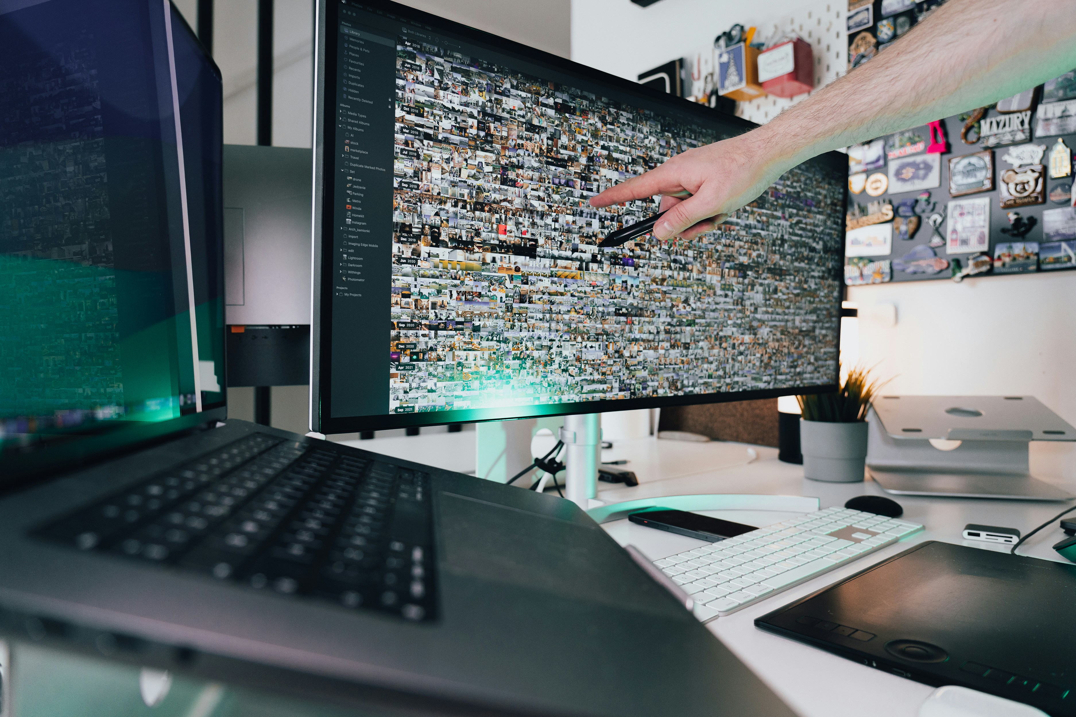 A person pointing at a computer screen on a desk photo – Free Table ...
