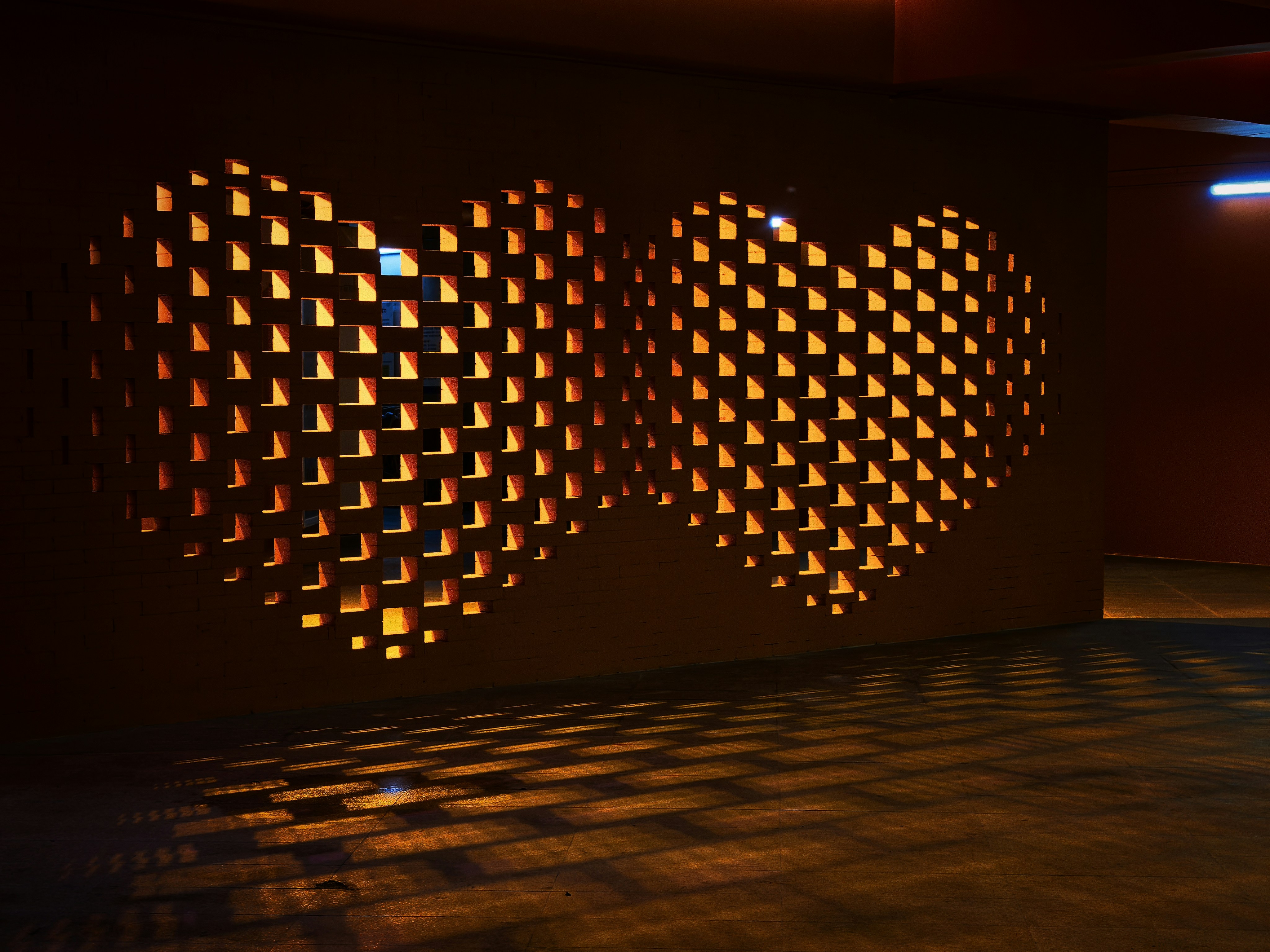 Two Glowing Honeycomb Hearts in a Dim Gallery
