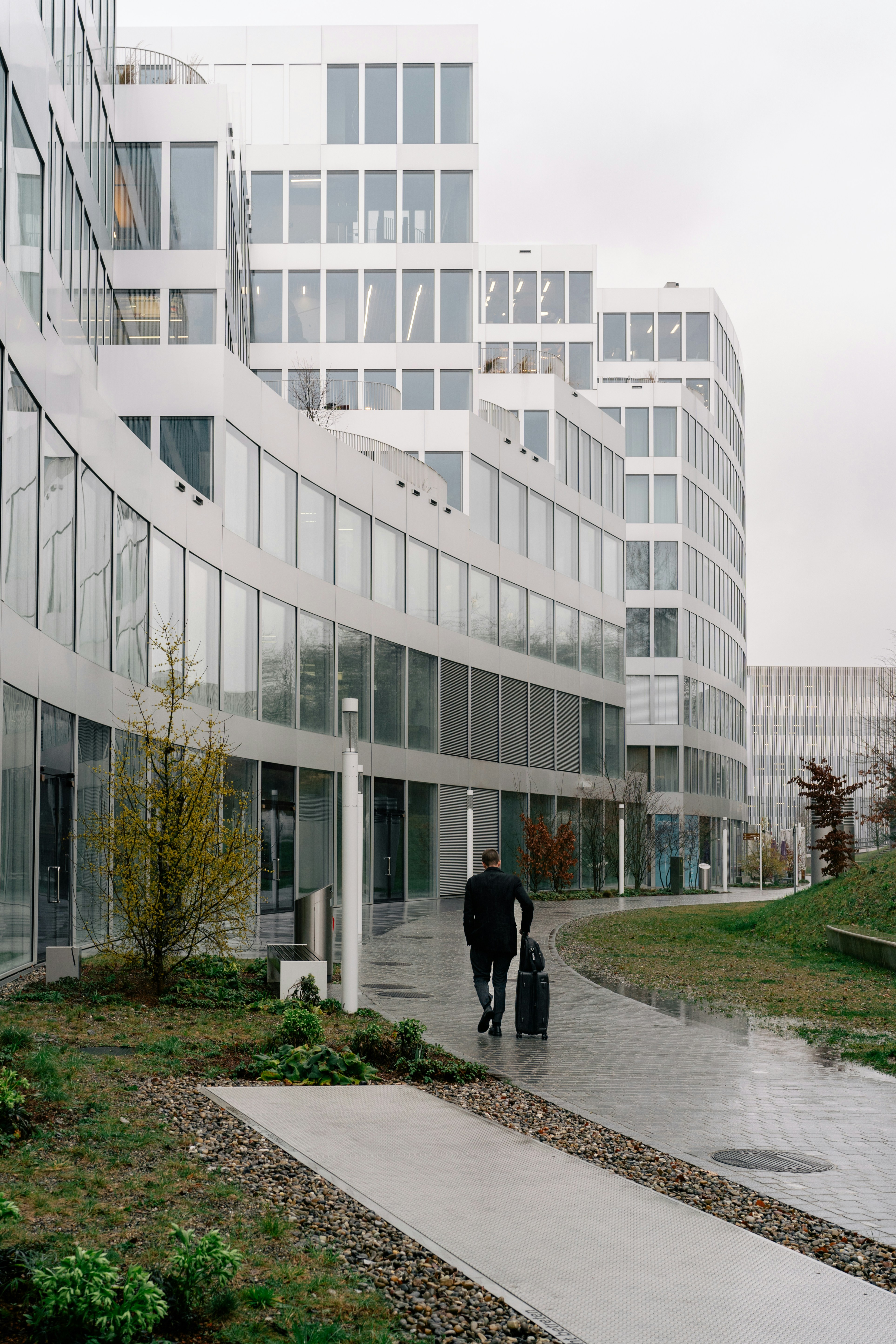 a man with a suitcase walking towards a building