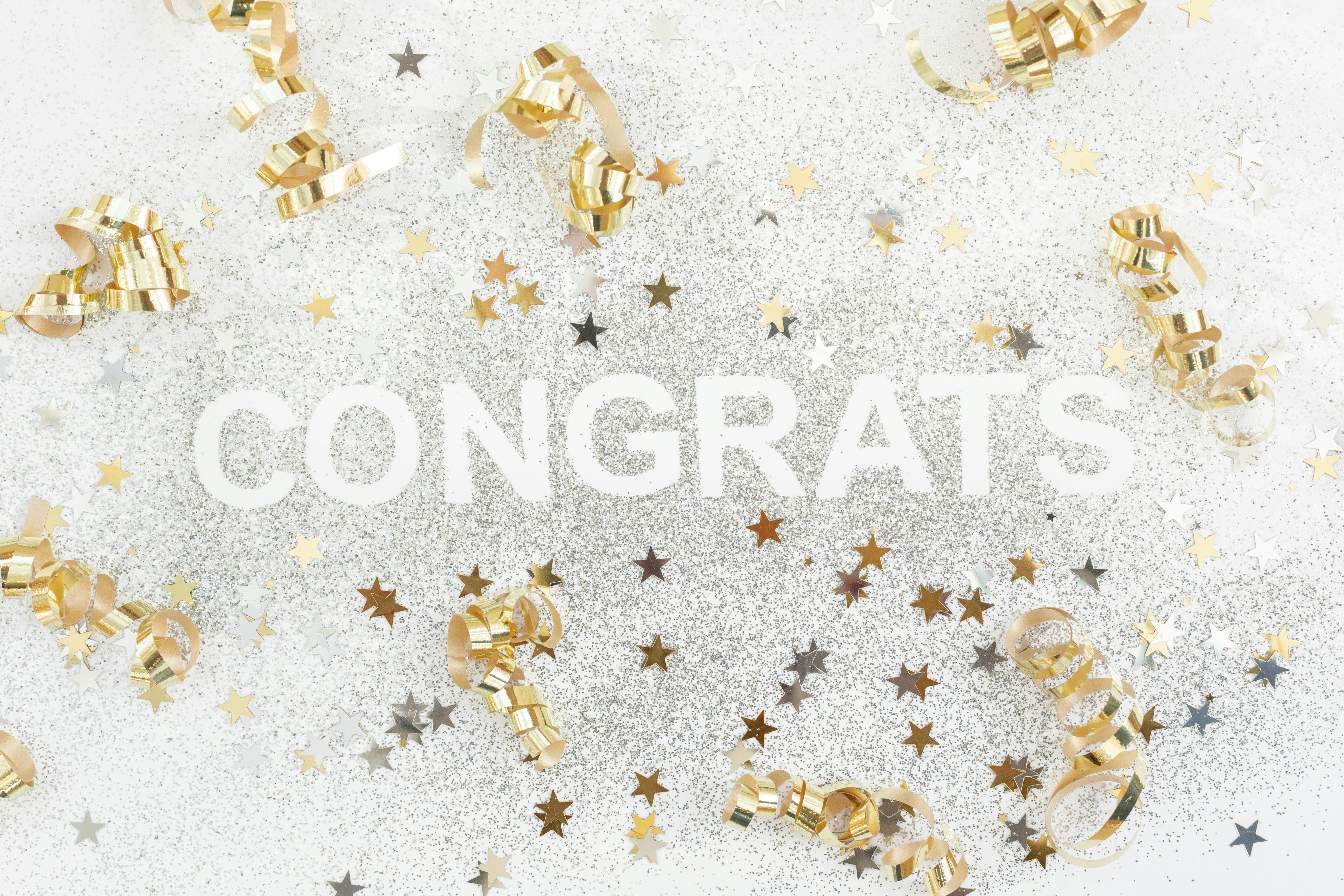 Gold and silver confetti with the word congrats surrounded by confe ...