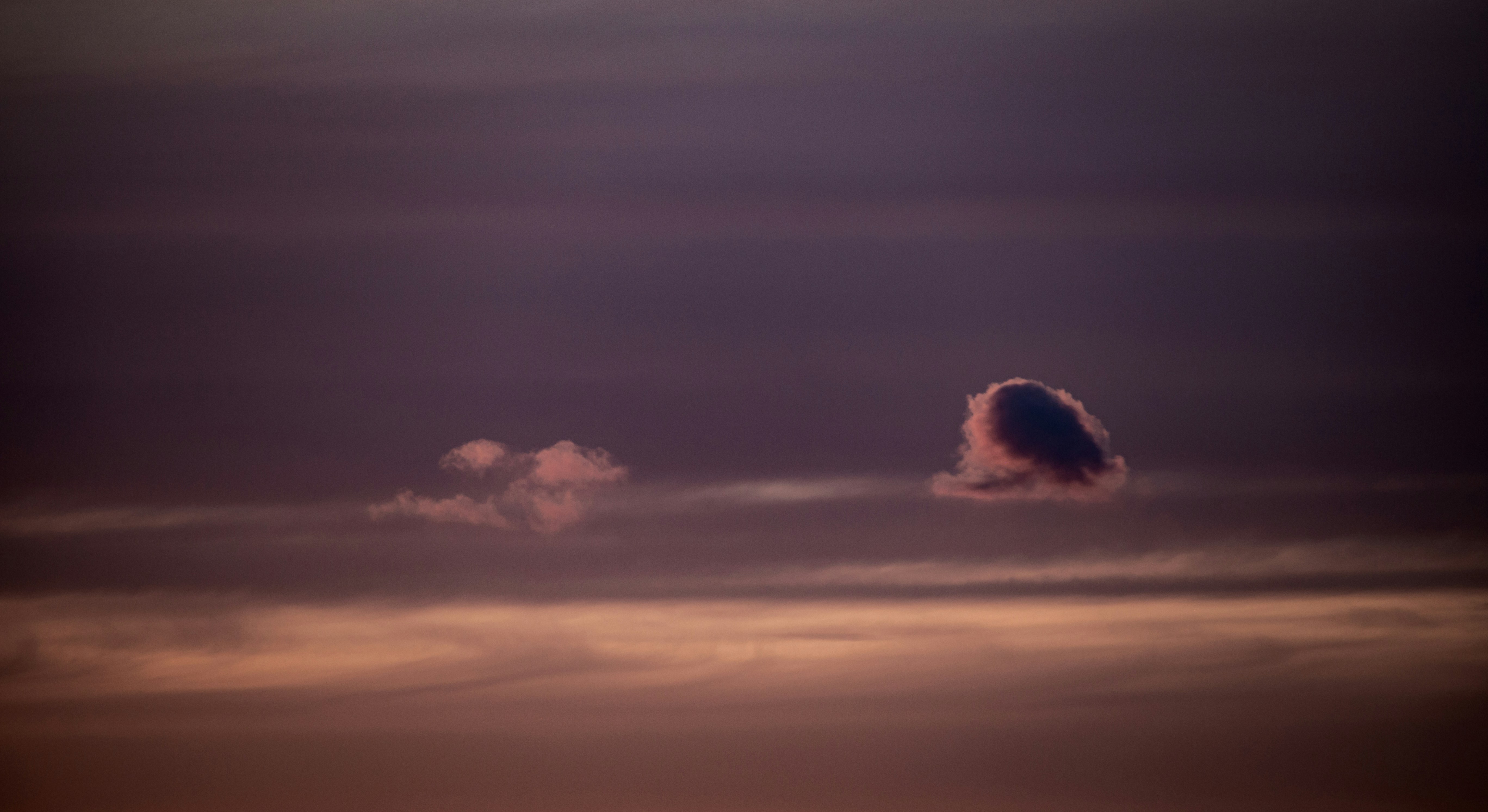 Dusk's Velvet Crest: A Lone Cloud Drifts Across a Purple-Orange Sky