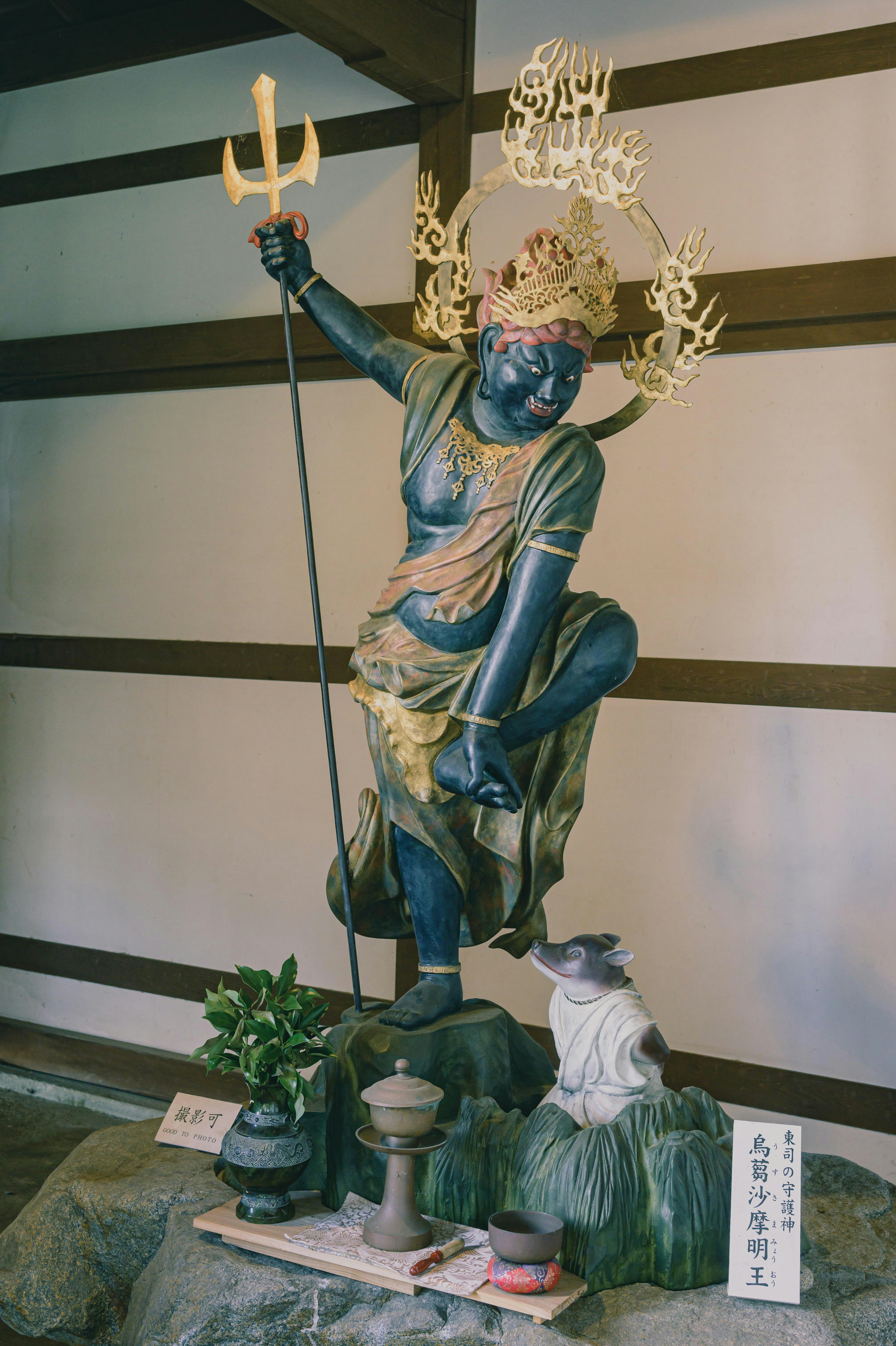 Trident Guardian: Blue Deity Amid Temple Offerings