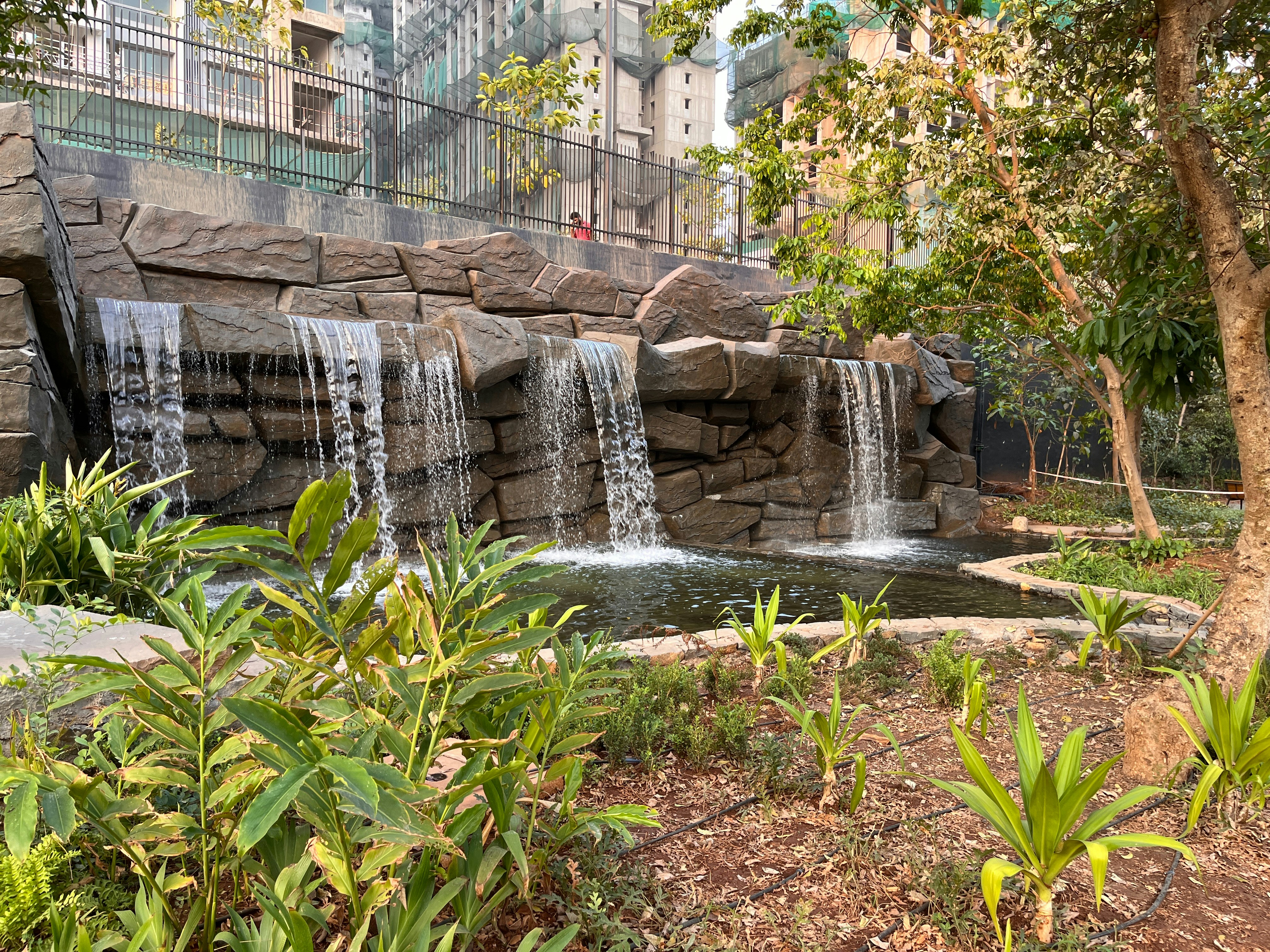 City Garden Cascade: Narrow Waterfalls Framing a Sunlit Urban Oasis