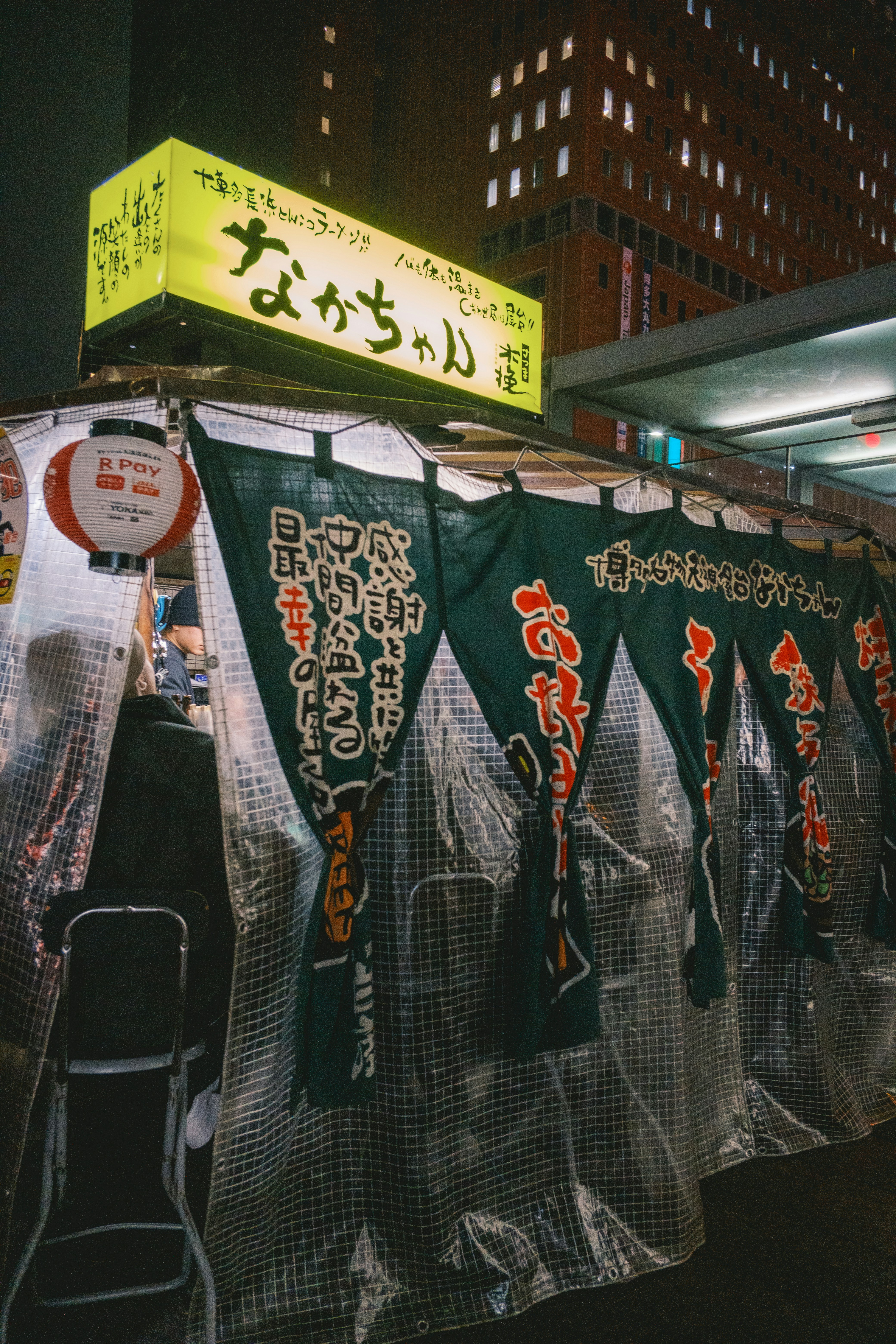 Night Market Corridor: Neon Yellow Sign Over Green Noren Draperies