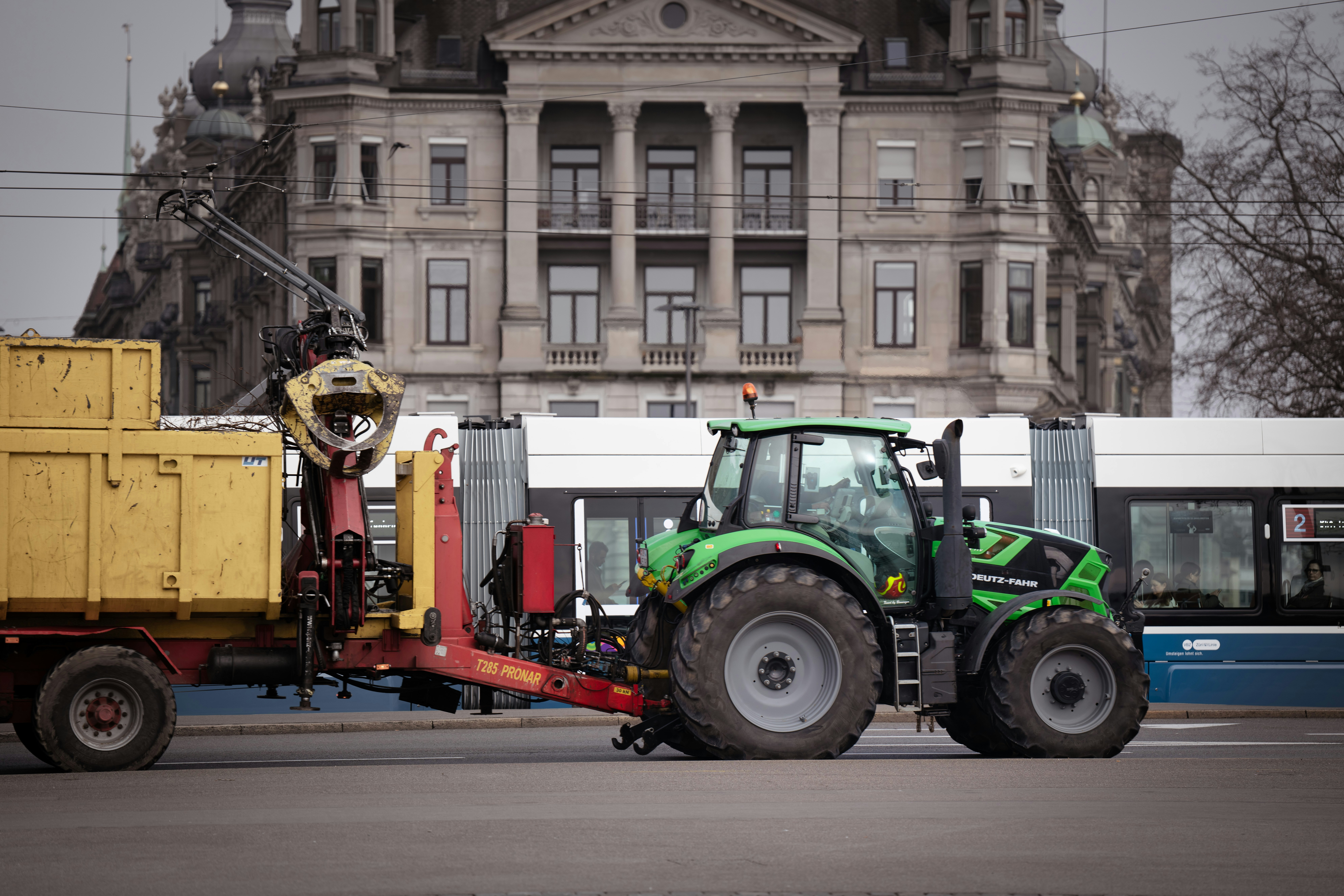 Green Tractor Haul Before a Neoclassical Backdrop