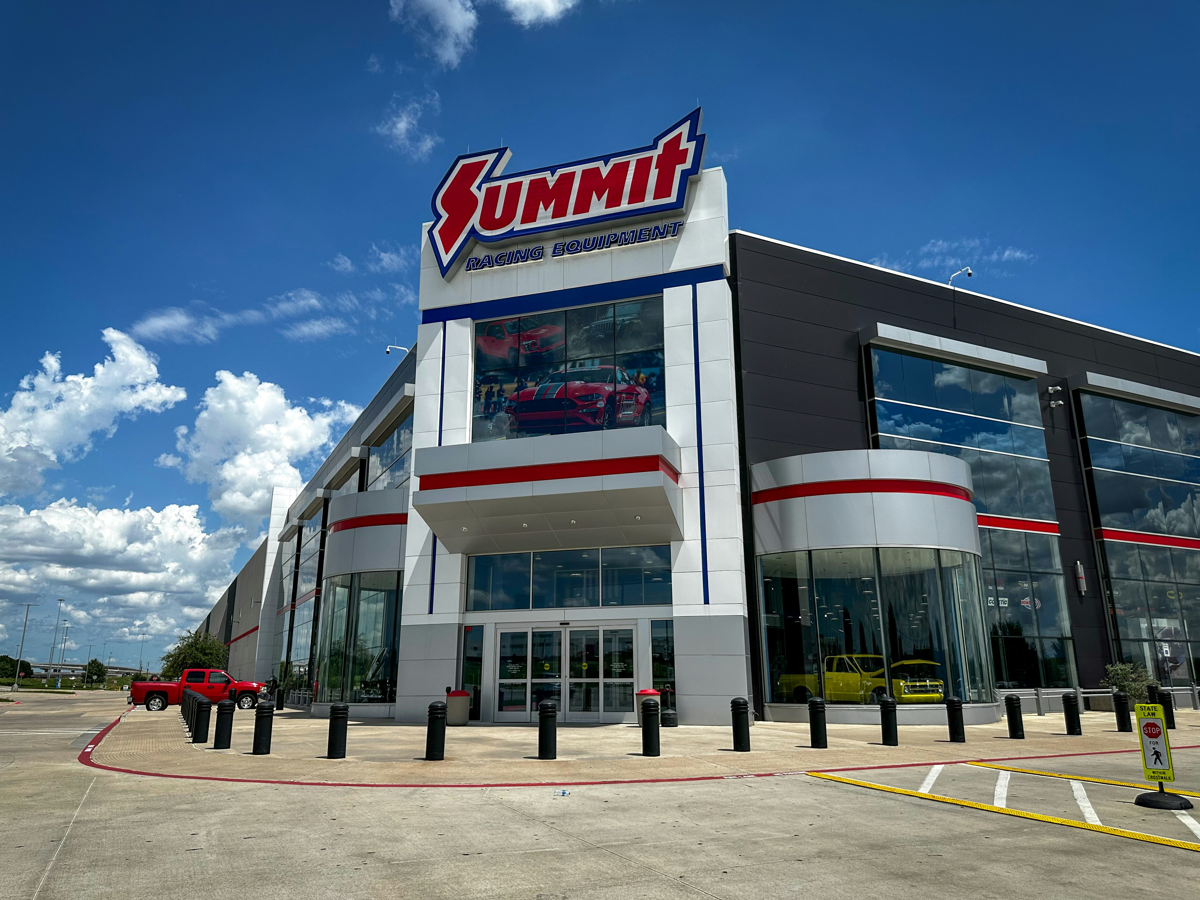 A large building with cars parked in front of it photo – Free Car Image ...