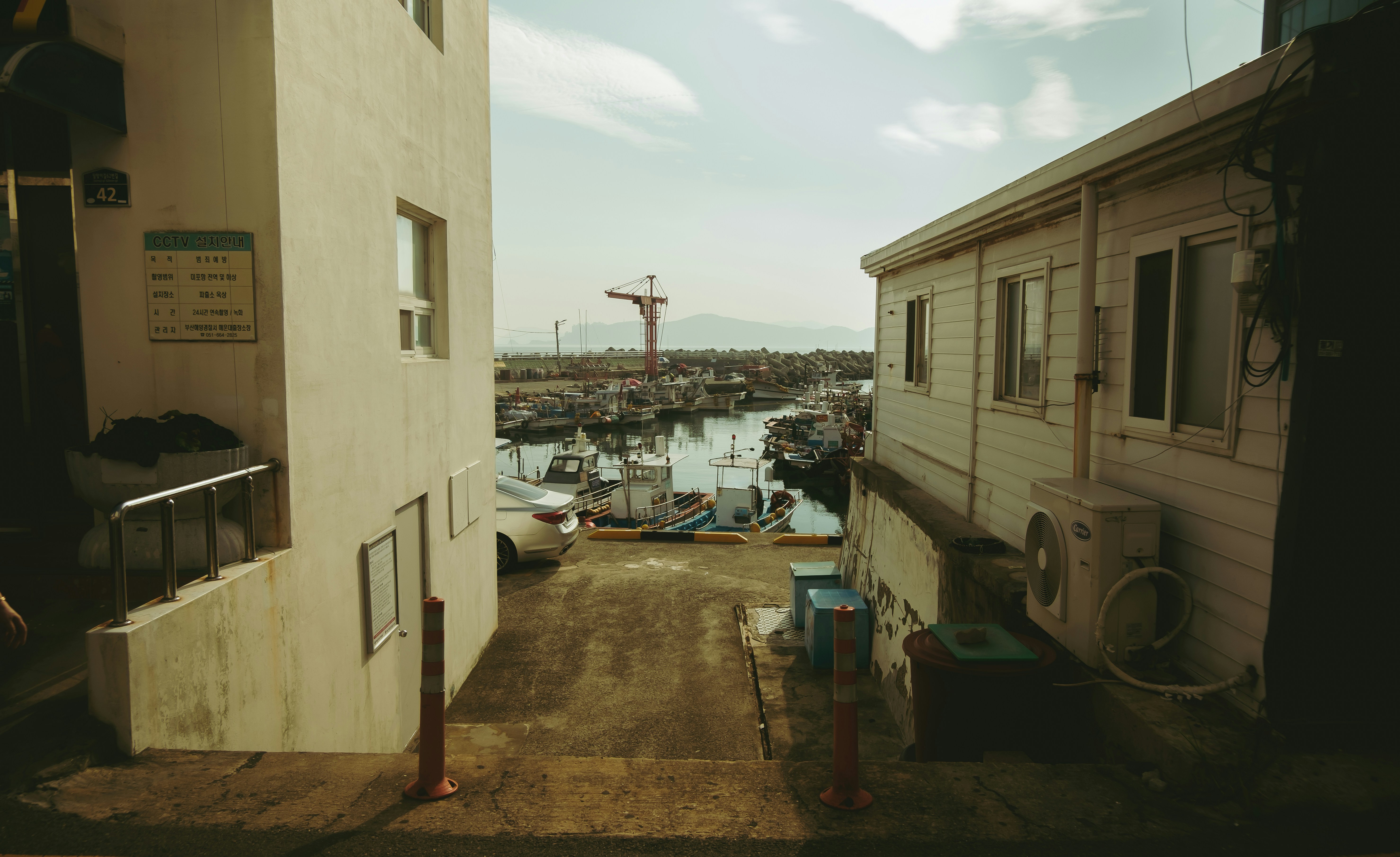 Harbor Gate: Boats Repose Beyond a Narrow Junkyard Corridor