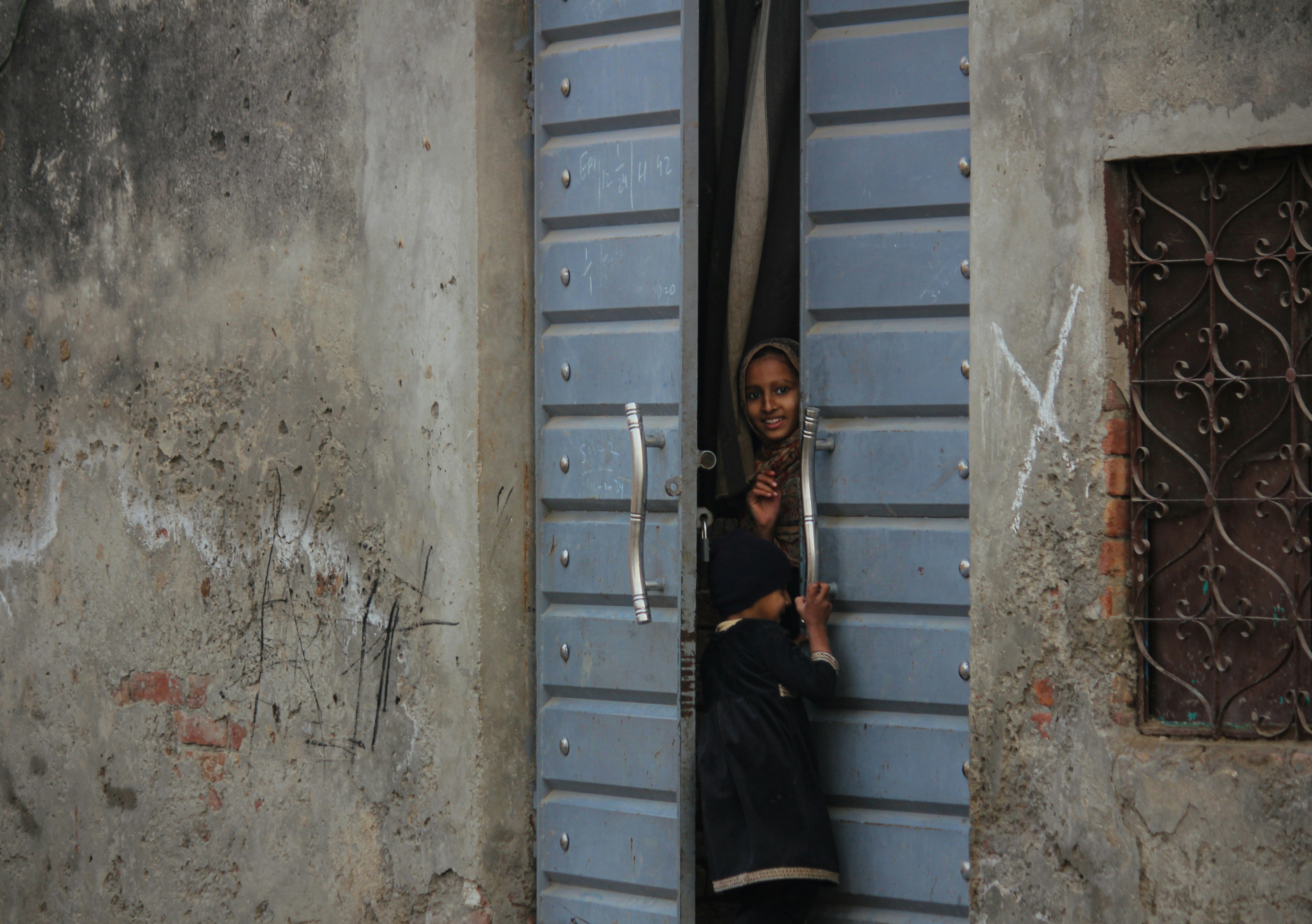 A woman standing in a doorway of a building photo – Free Lahore Image ...
