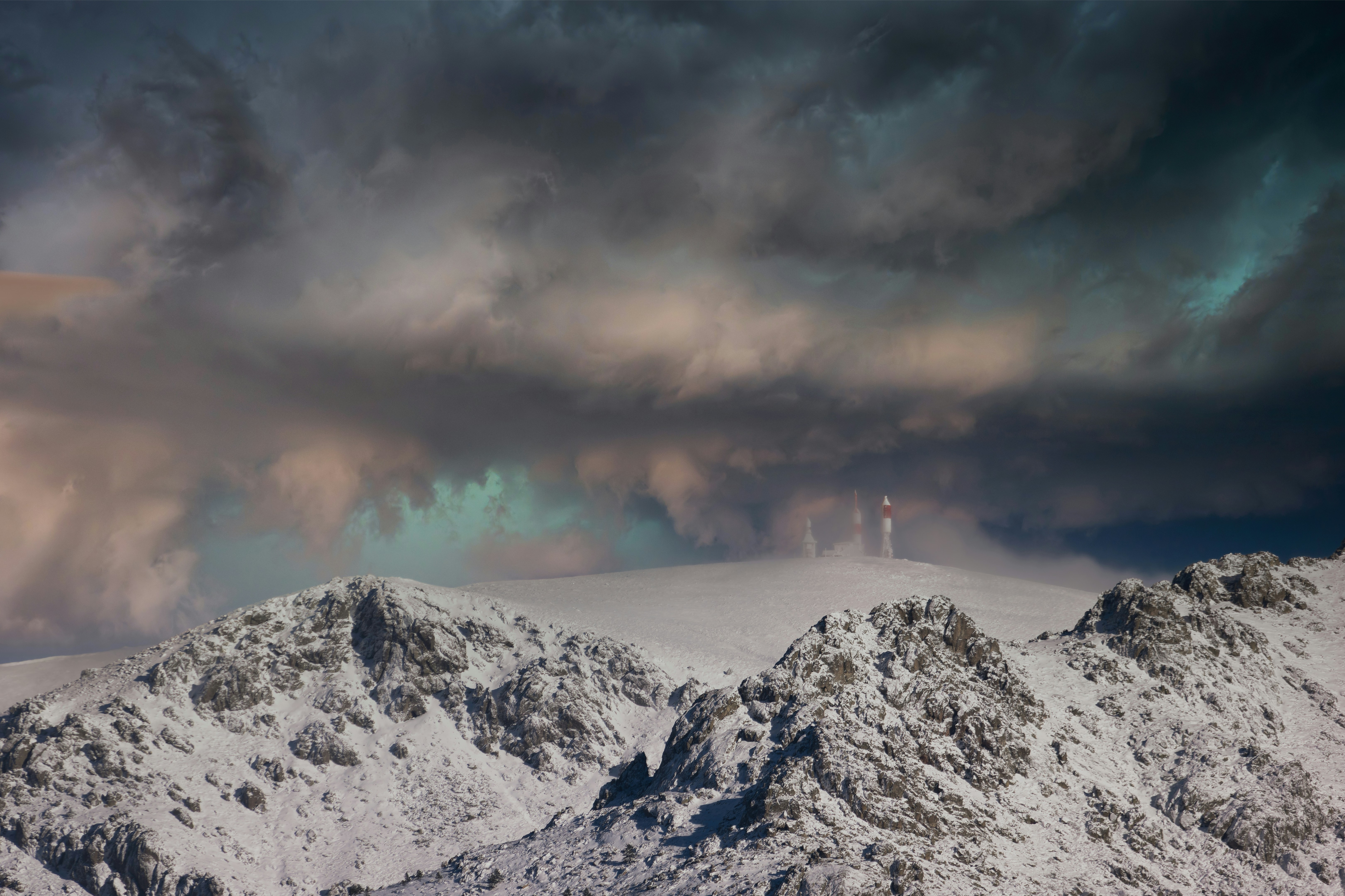 Storm-Scarred Summit: Snow-Crest Ridge Under Roiling Skies