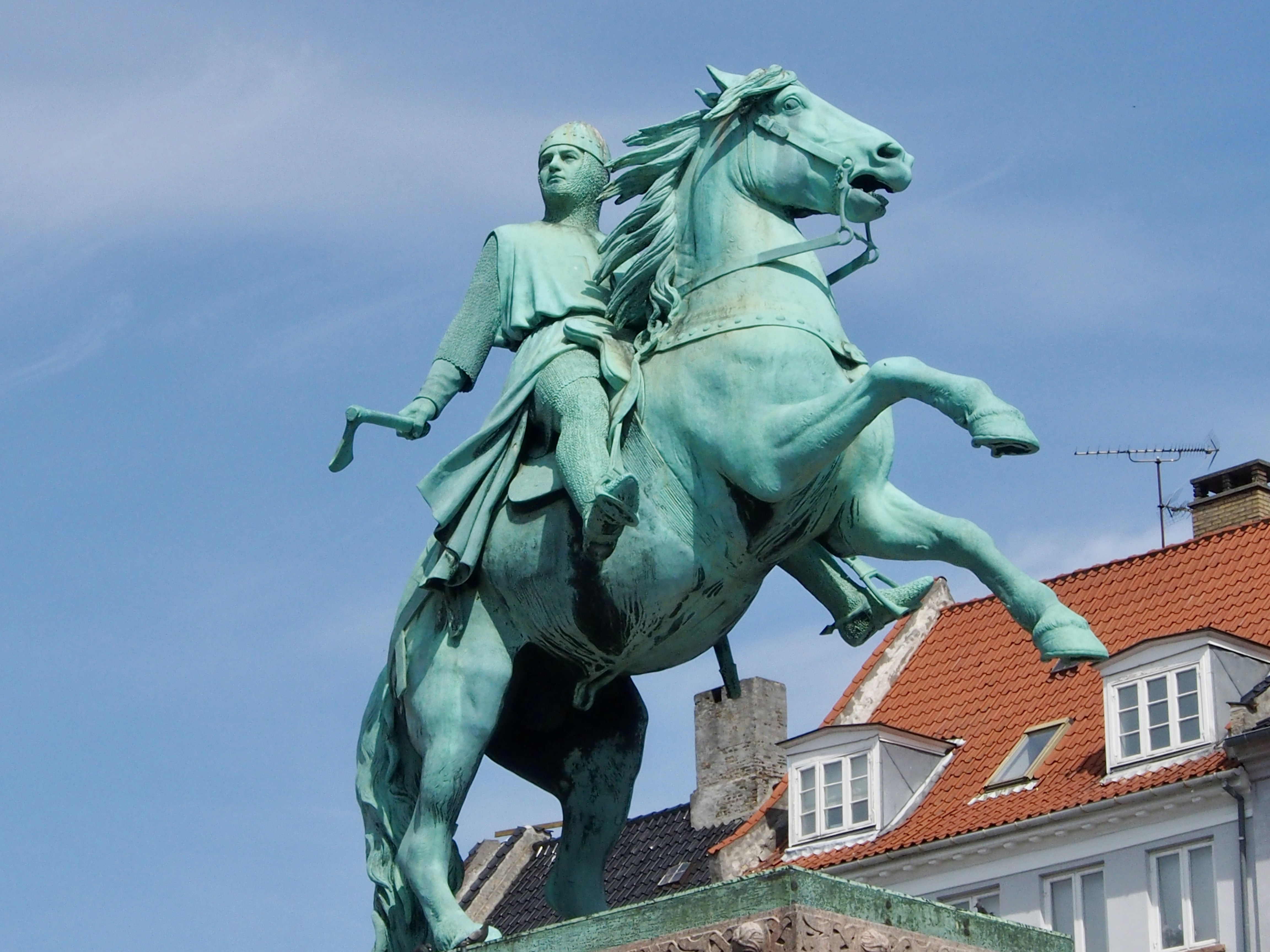 Bronze Rider in Flight: A Statue Over a Rooftopped Town