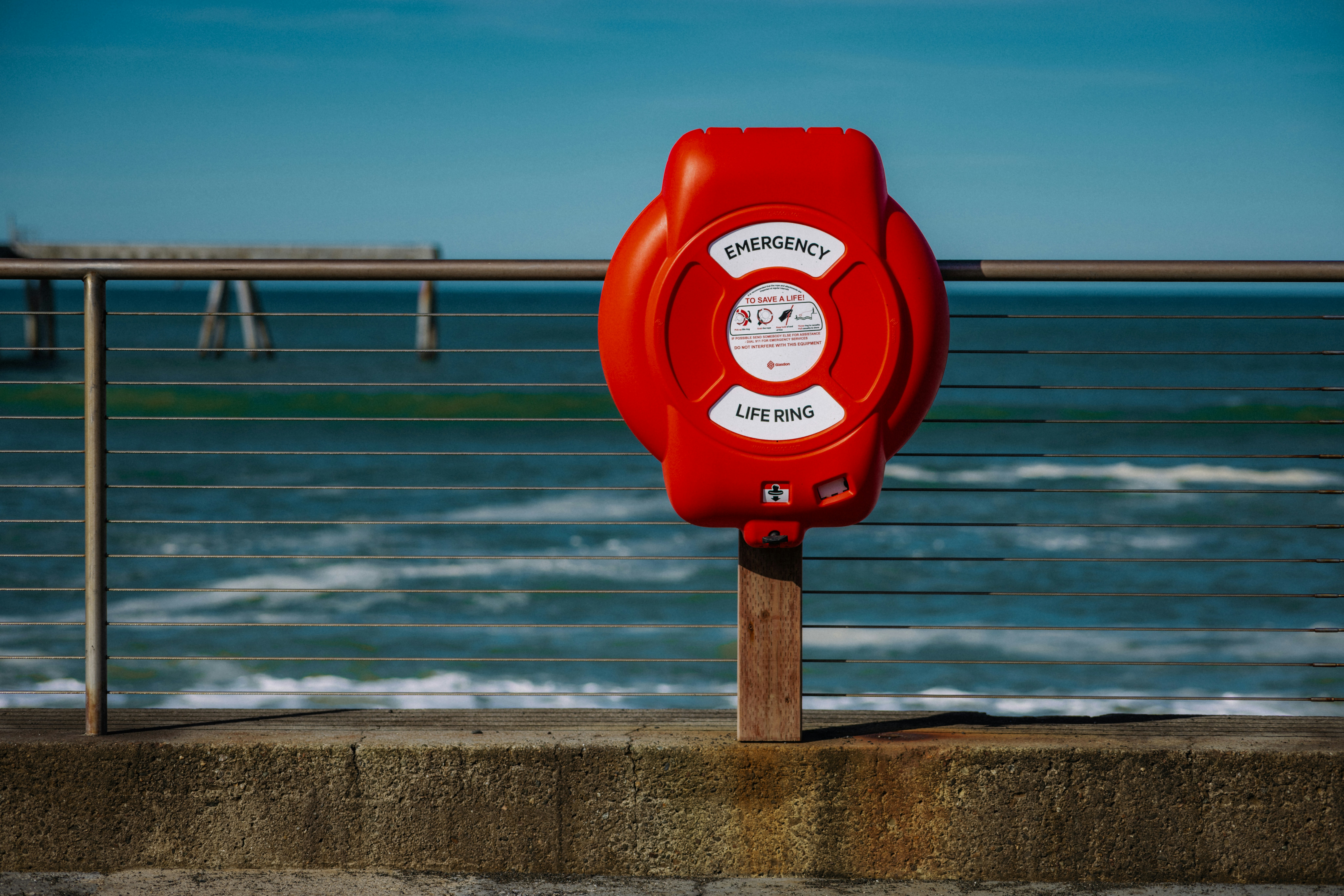 Crimson Lifebuoy Anchored by the Sea: a Quiet Coastal Portrait