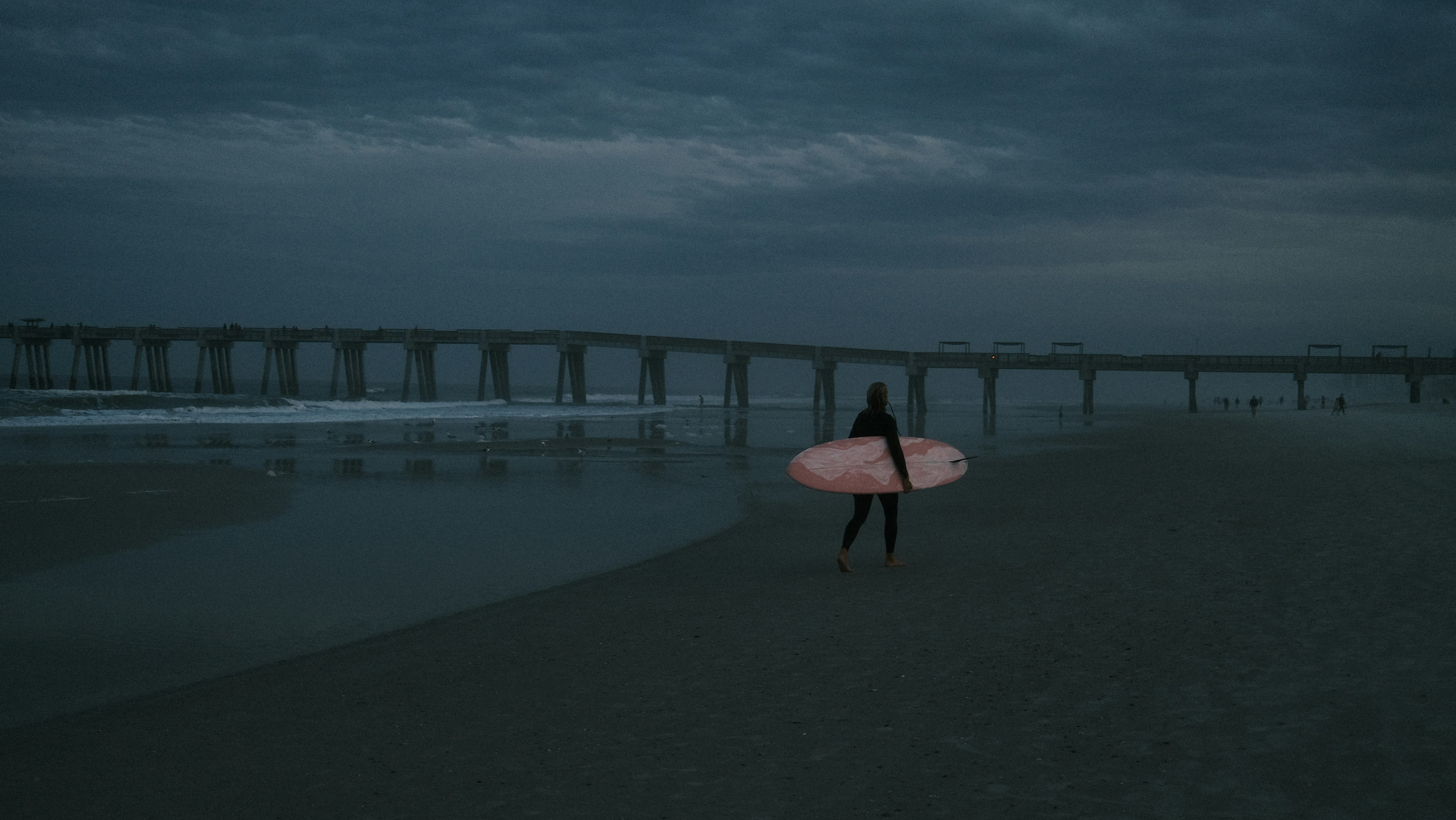 Pink Surfboard at Dusk: Silhouettes and Pier Lines