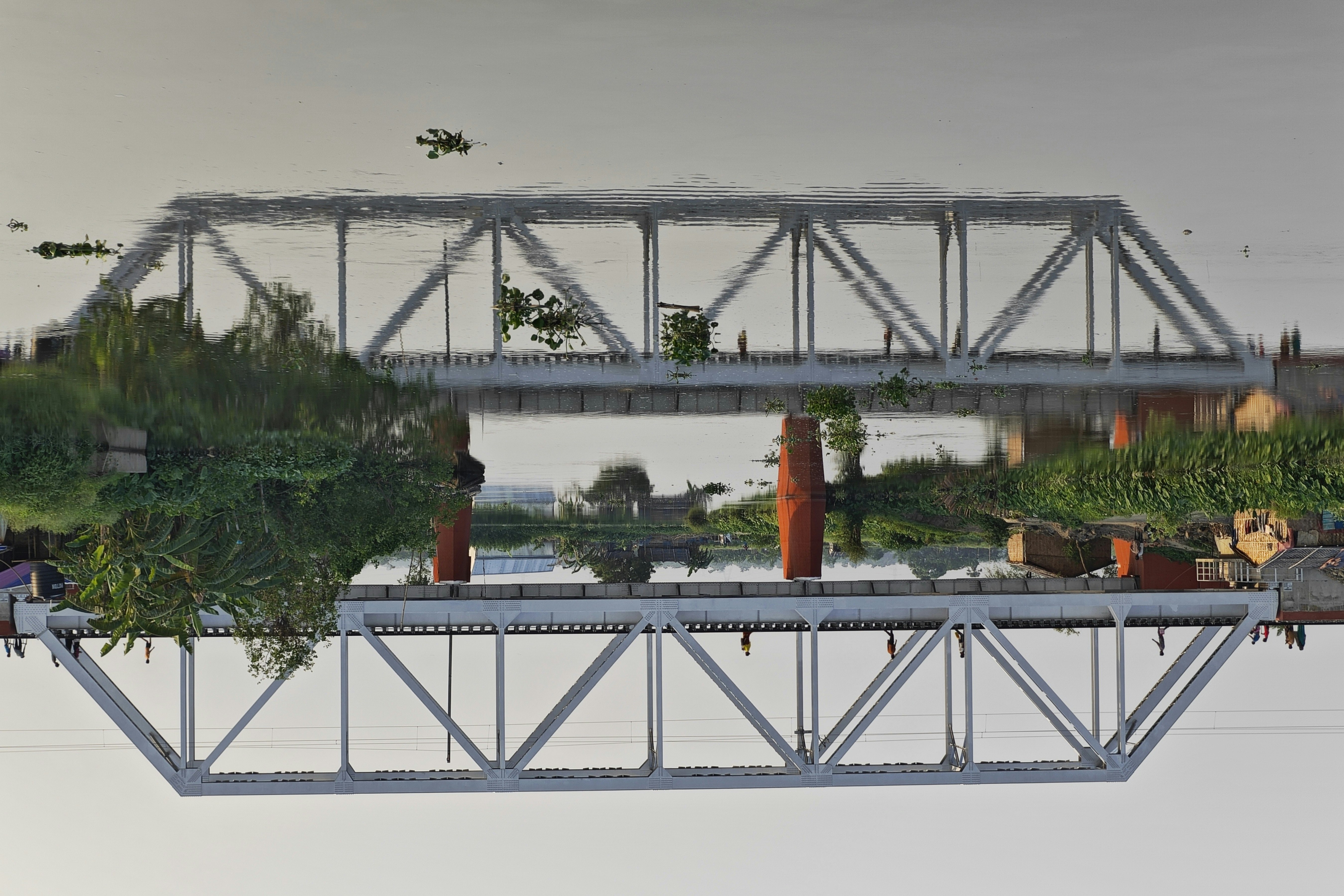 Twin Truss Reflections: Steel Bridge Over a Quiet River