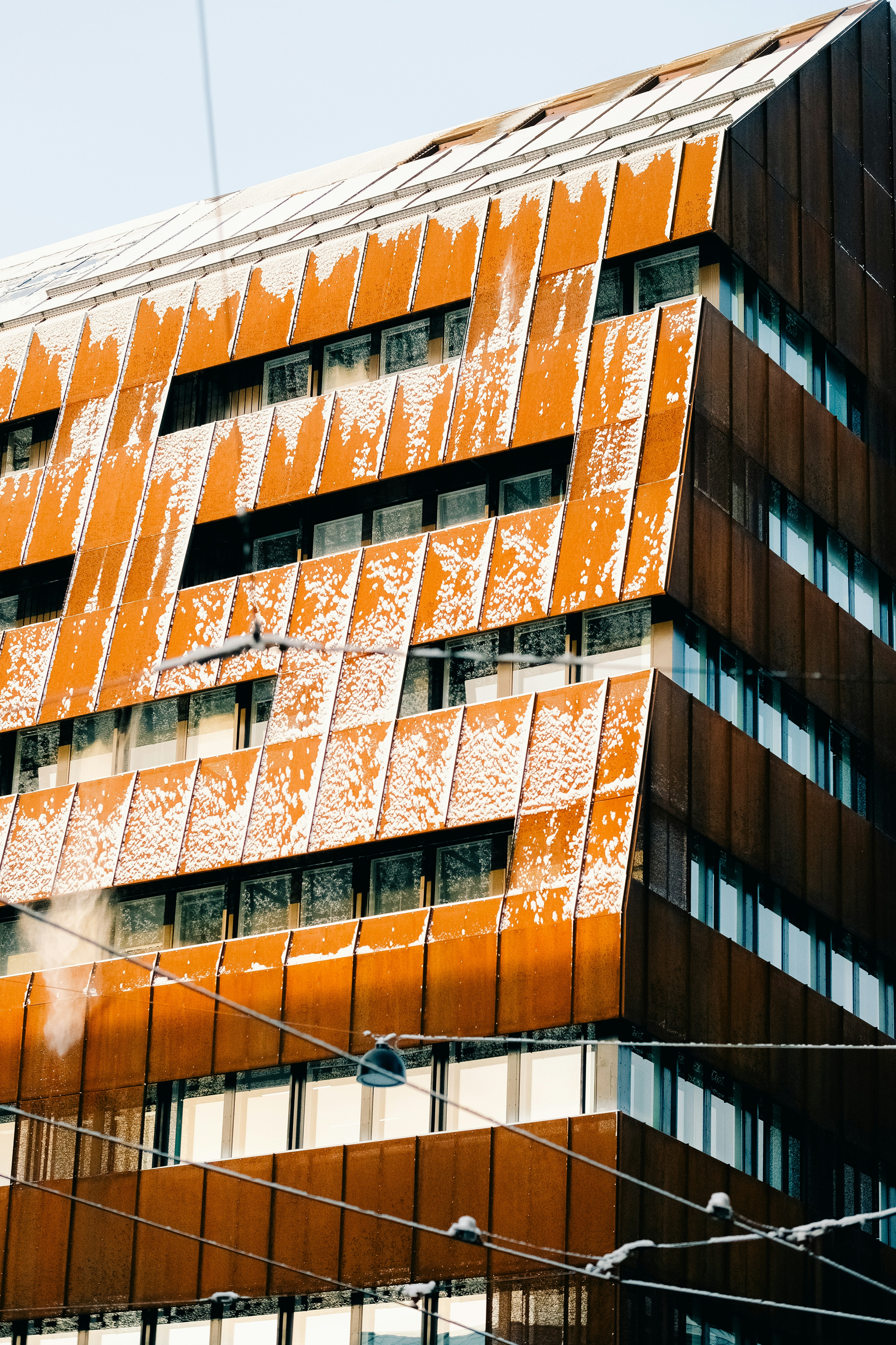Orange Strata: A Geometric Facade Rising Across a Wintery Skyline