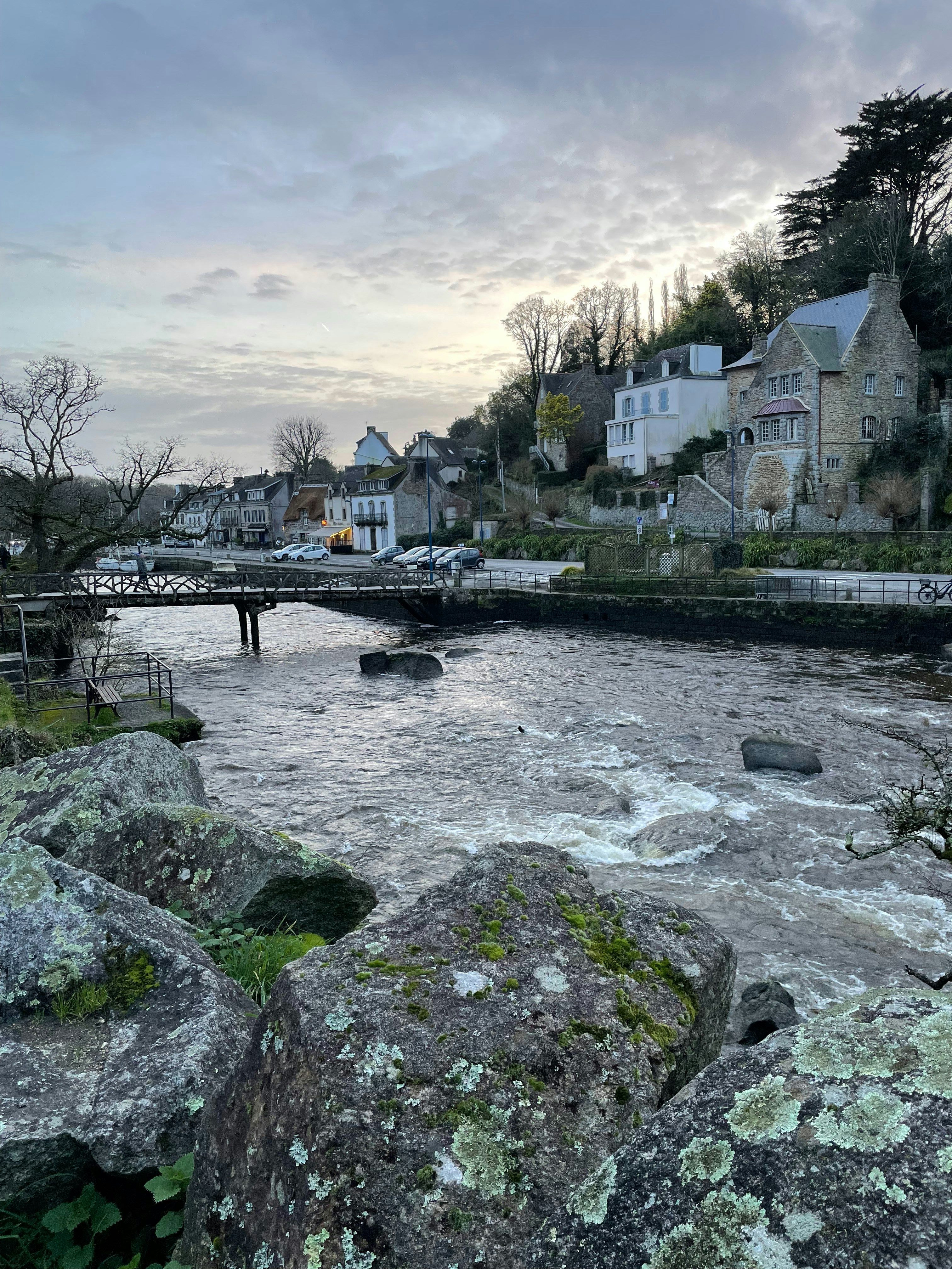 Bridge of Quiet Currents: Mossy Rocks Framing a Stone-Cottage Riverside