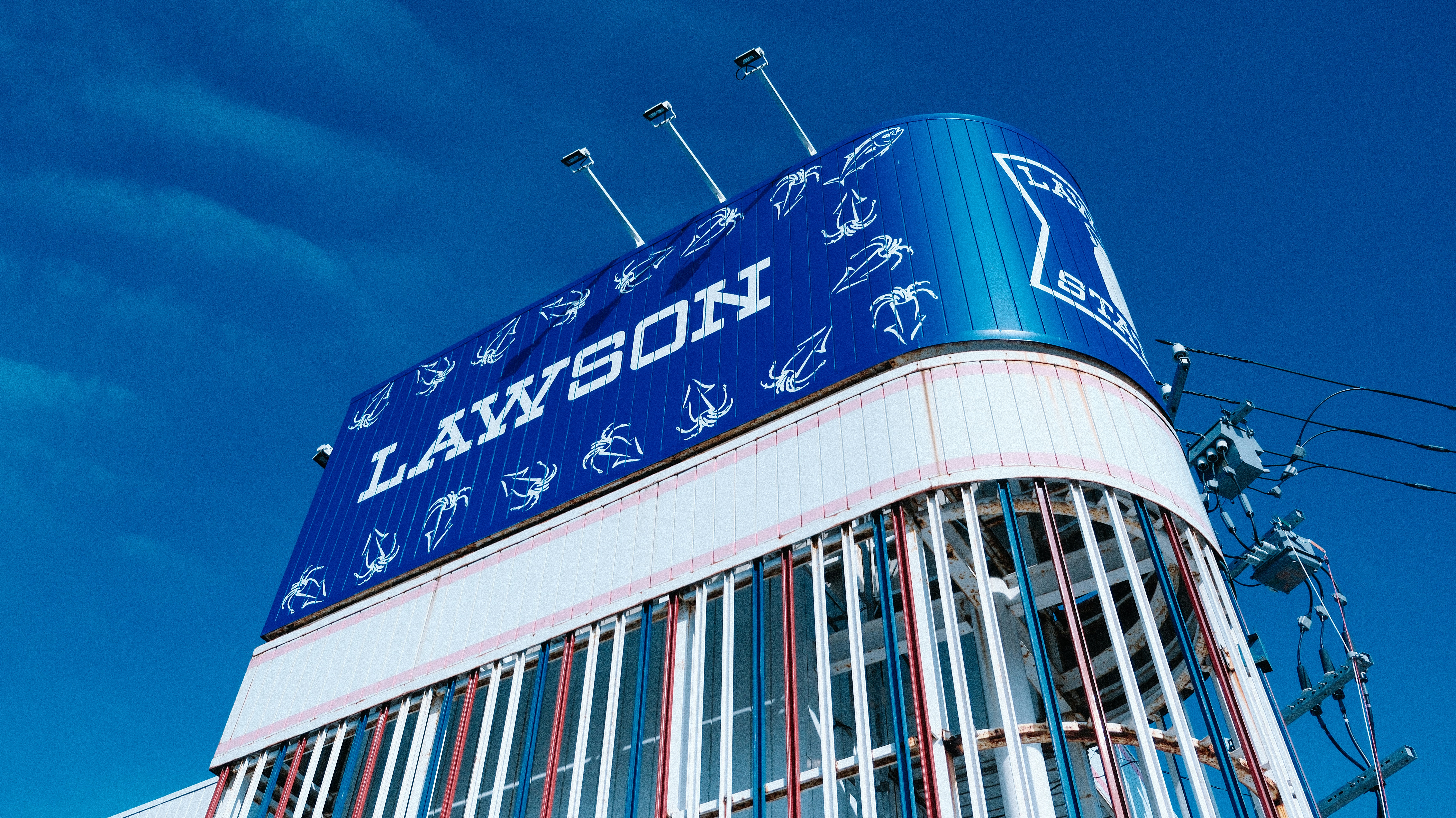 Lawson store sign against a vibrant blue sky.
