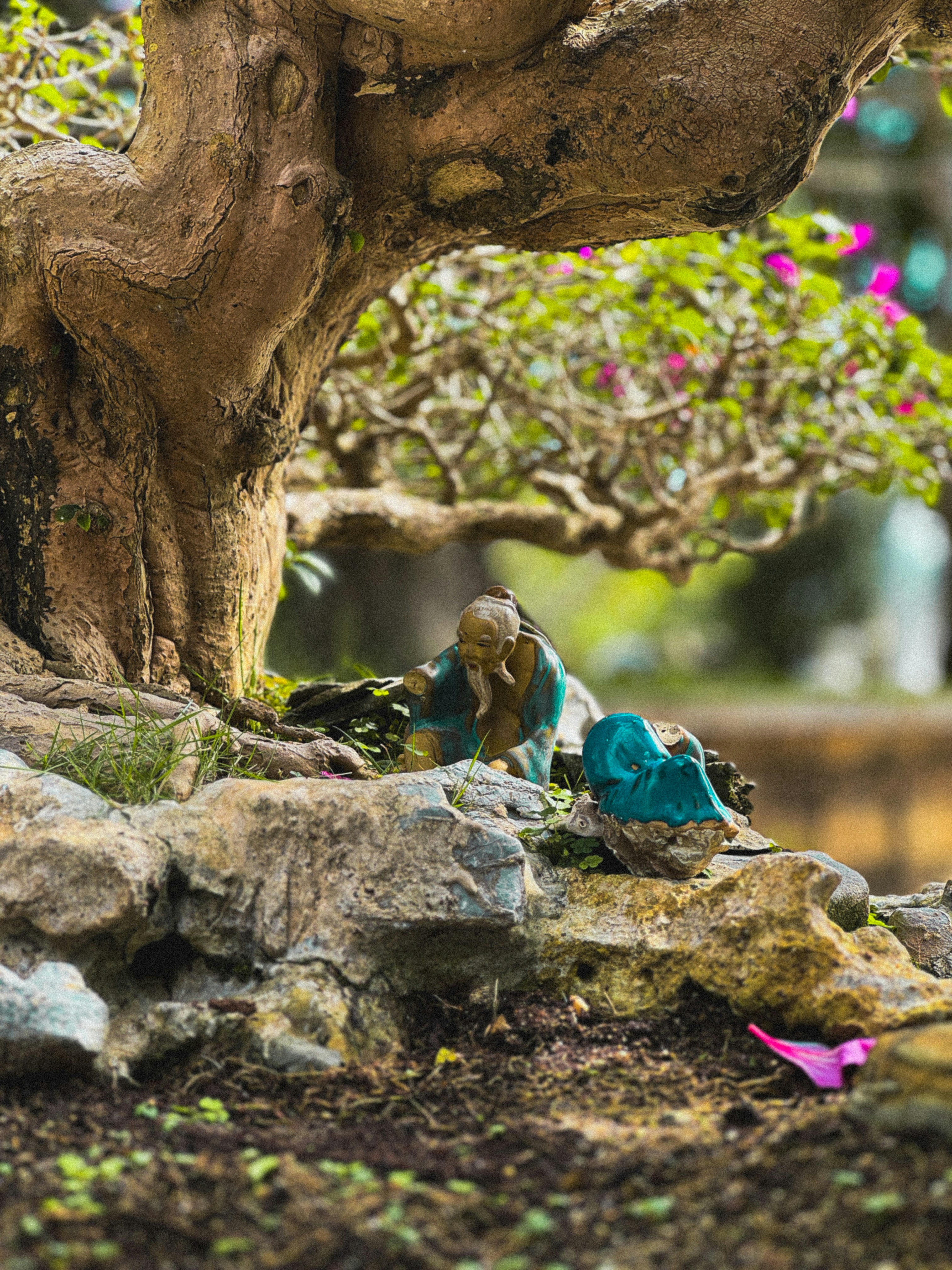 Tiny Gardener Figurine Nestled in a Weathered Rock Garden