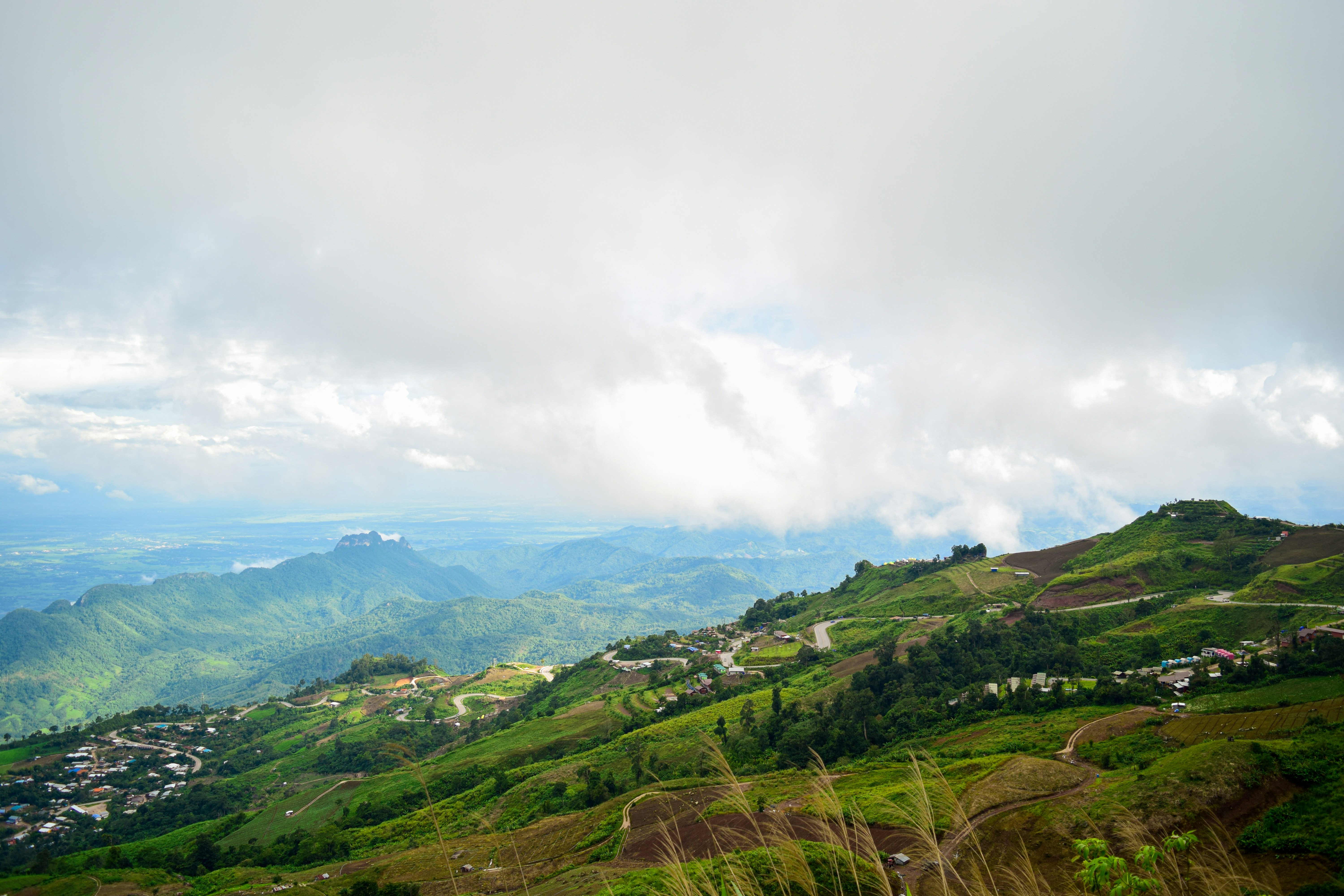 Lush green hills stretching into the distance under a cloudy sky.
