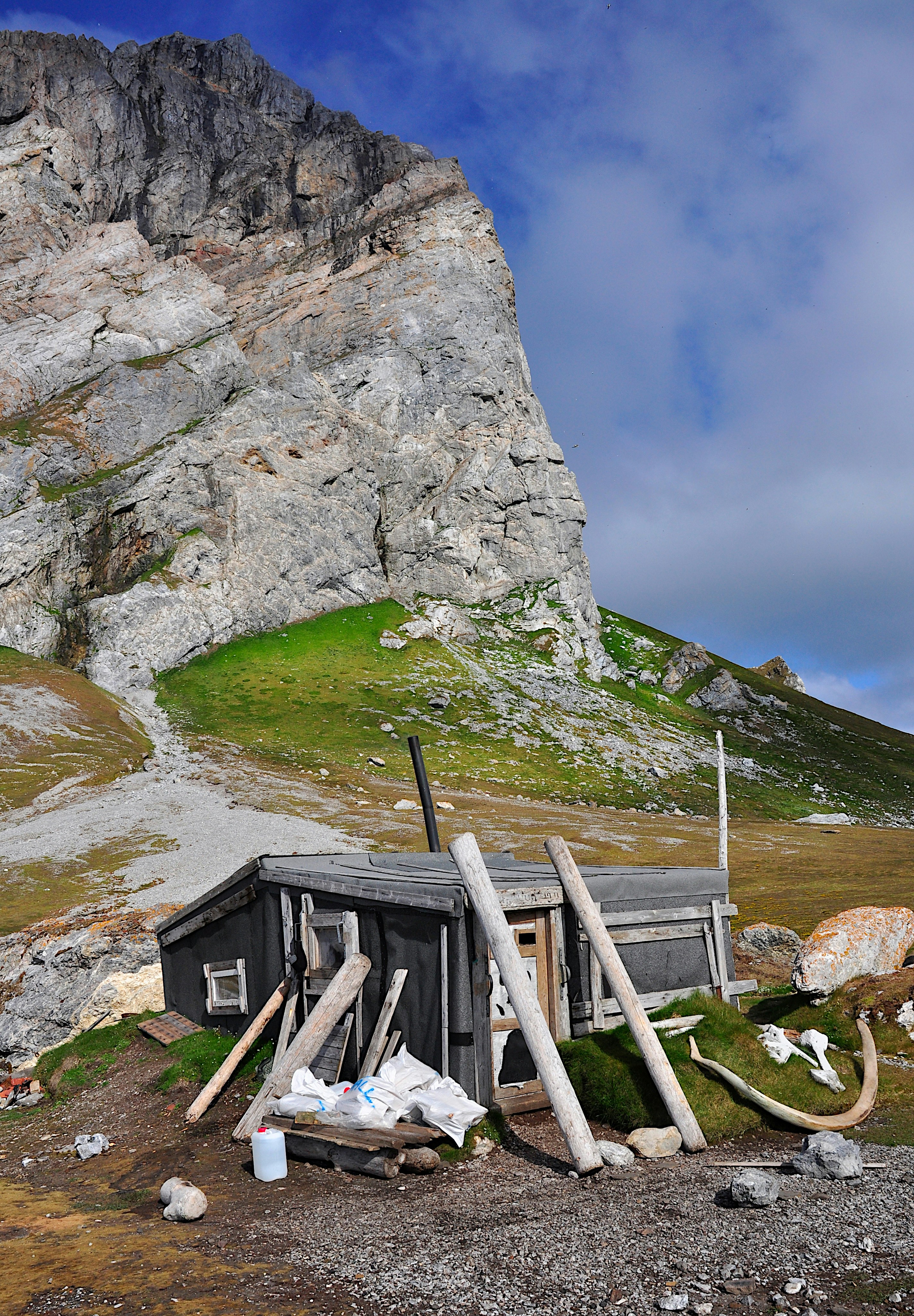 A pile of junk sitting on top of a grass covered hillside photo – Free ...
