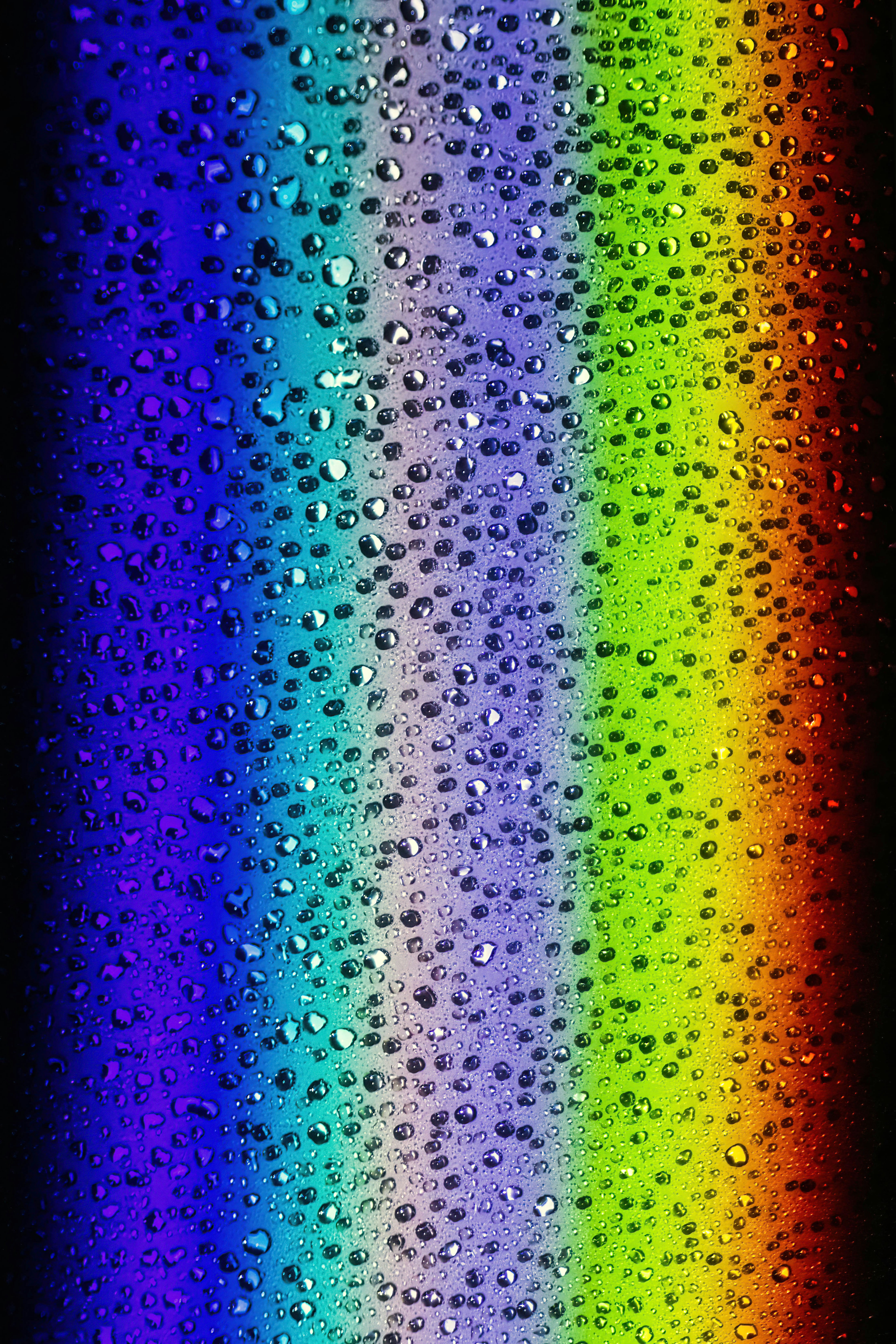 A rainbow of water droplets on a black background photo – Free ...