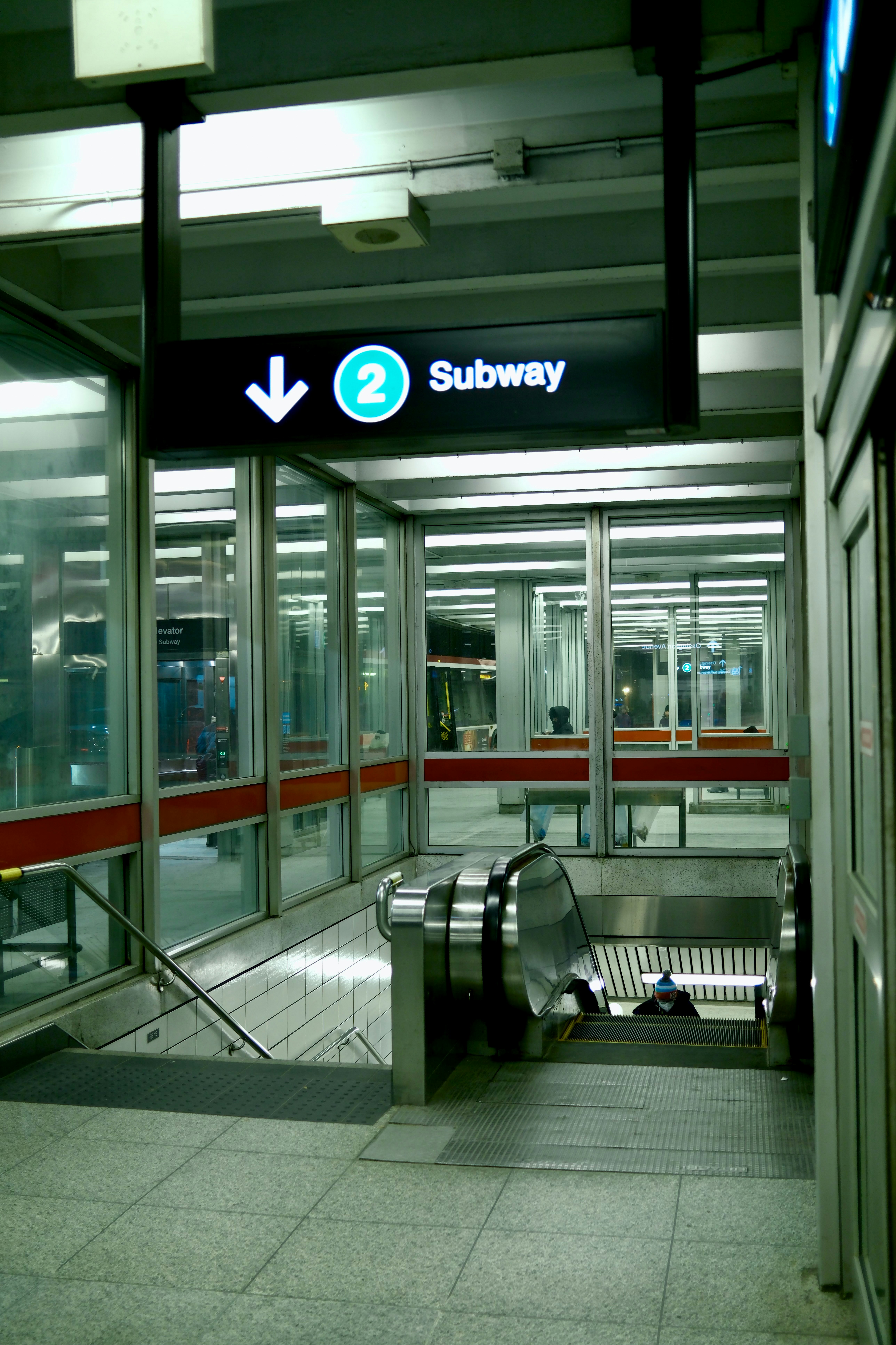 A subway entrance with an escalator and a bench photo – Free Toronto ...