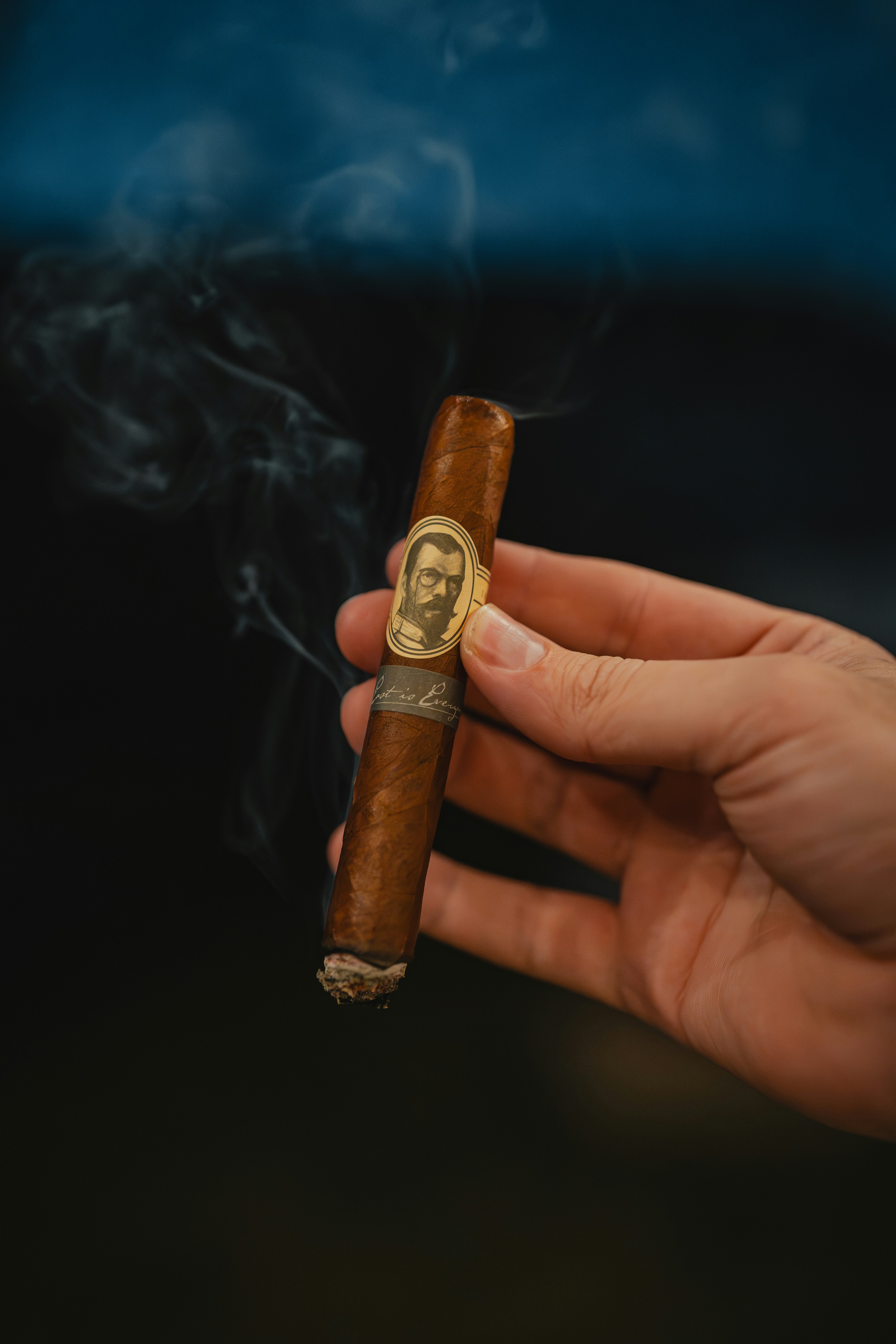 A person holding a cigar in their hand photo – Free Cigar Image on Unsplash