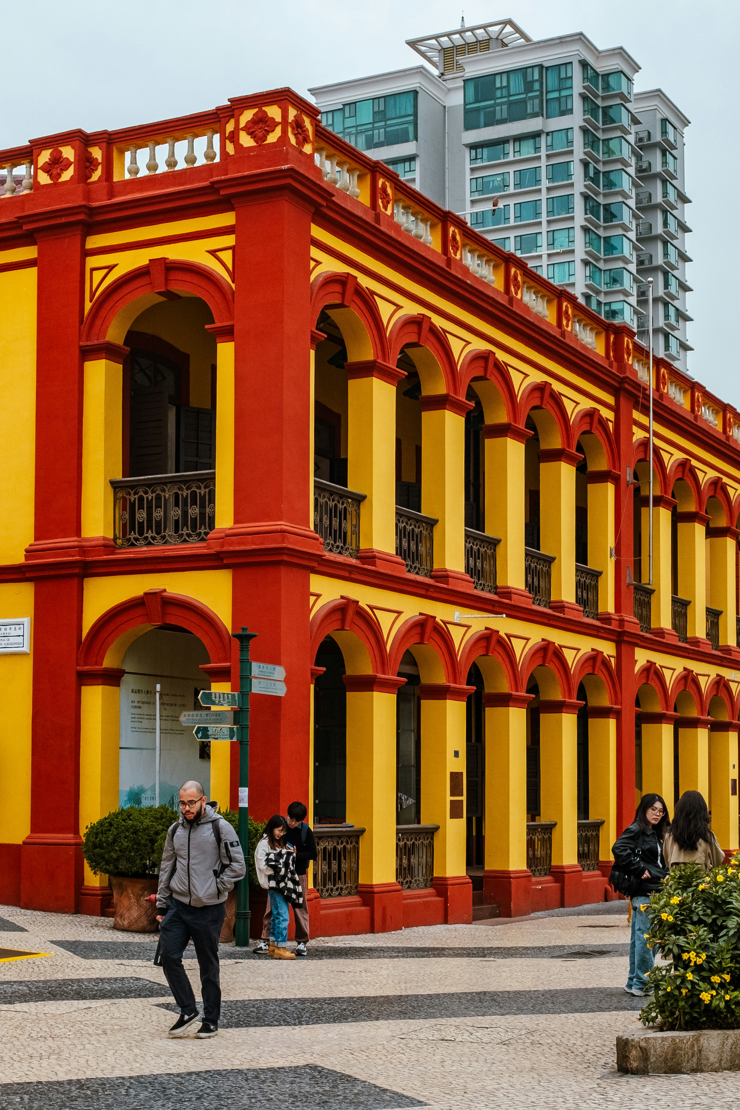 A red and yellow building with people walking around photo – Free Macau ...