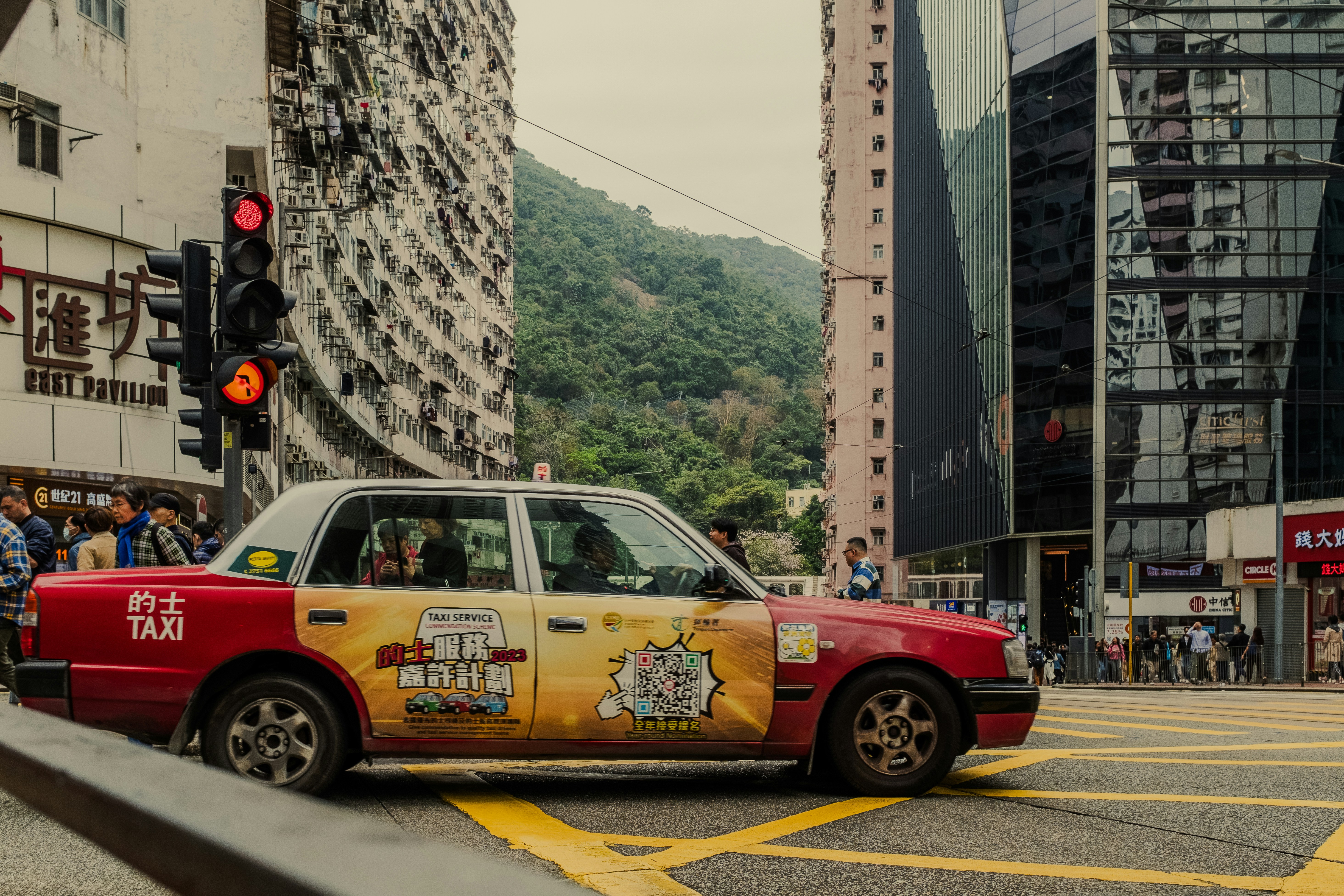 Urban Taxi Crest: A Colorful Ride Amid City Glass and Hills