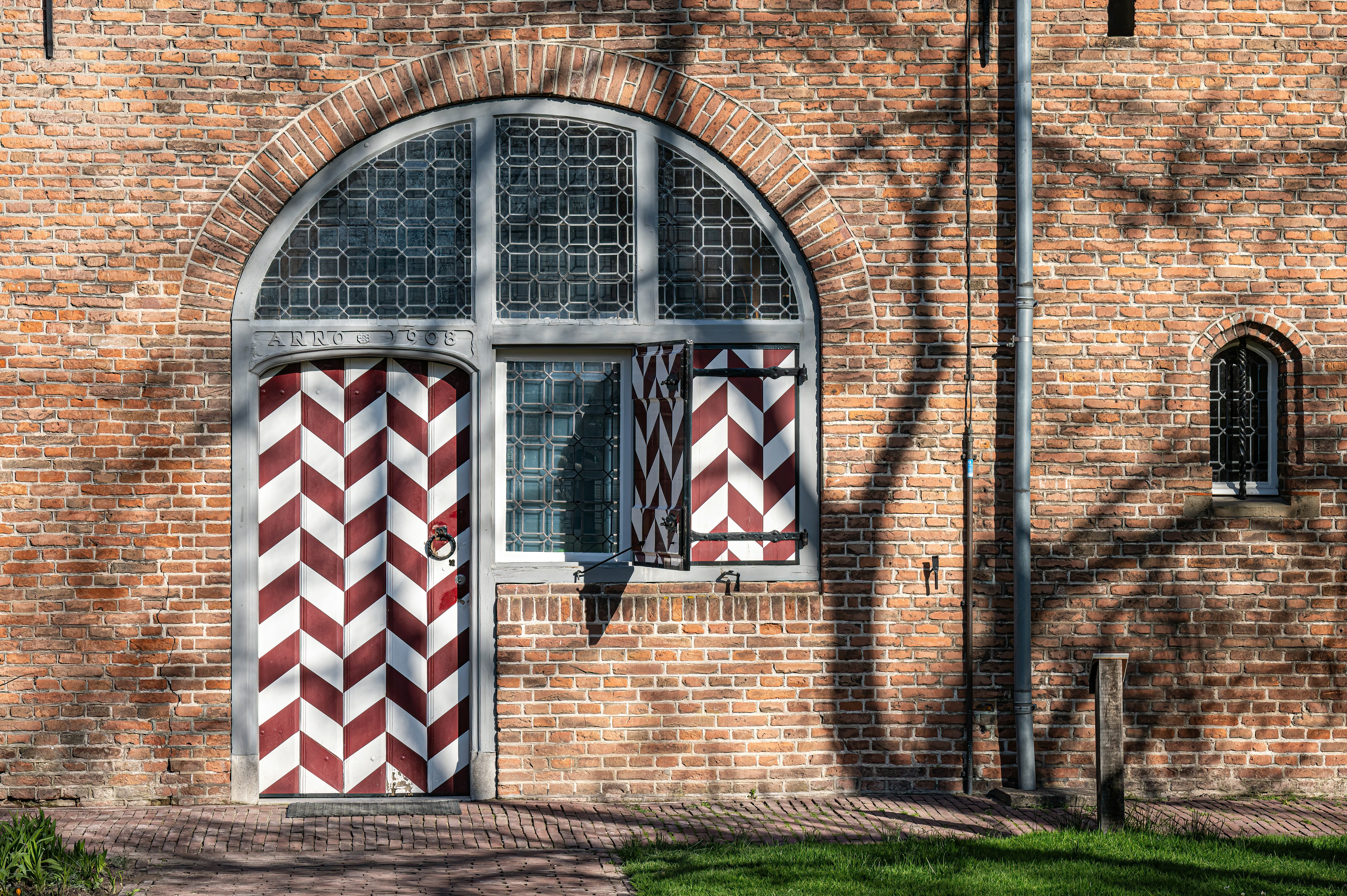 Diagonal Stripes at the Brick Arch: Sunlit Doorway on a Shadowed Facade