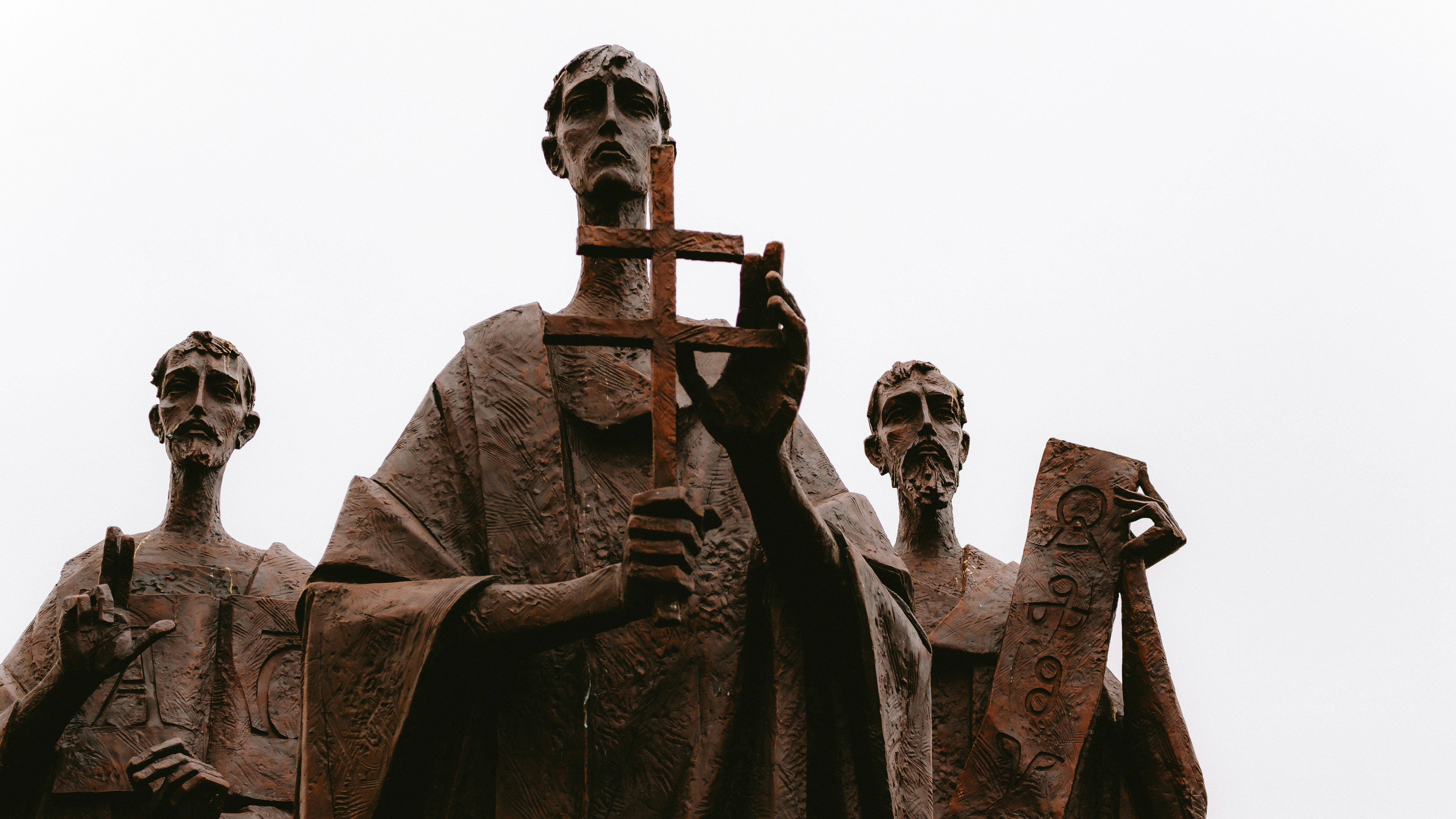Cross-Bearing Sentinel: A Quiet Triad of Monolithic Statues