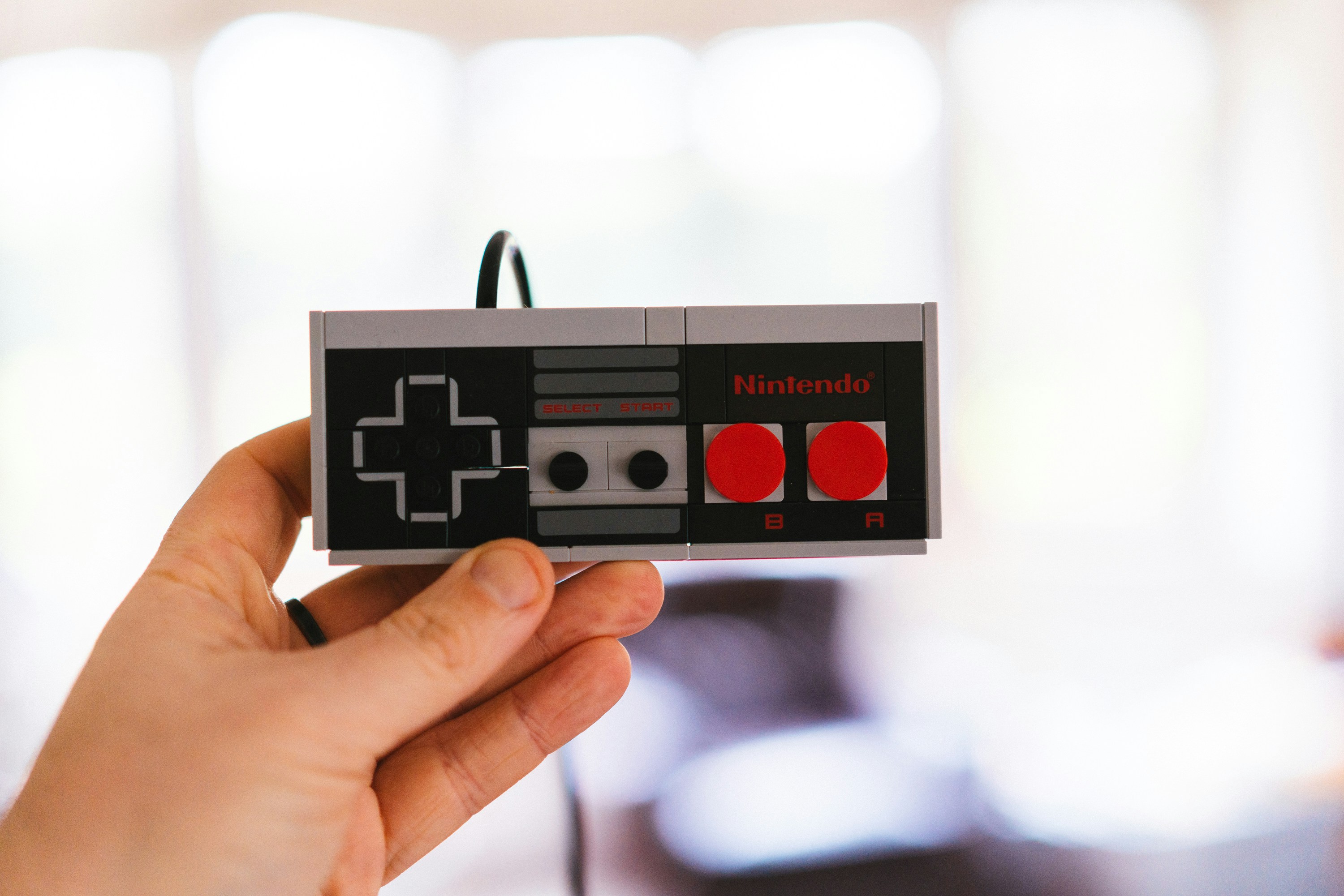 A hand holding a nintendo controller made out of legos photo – Free ...