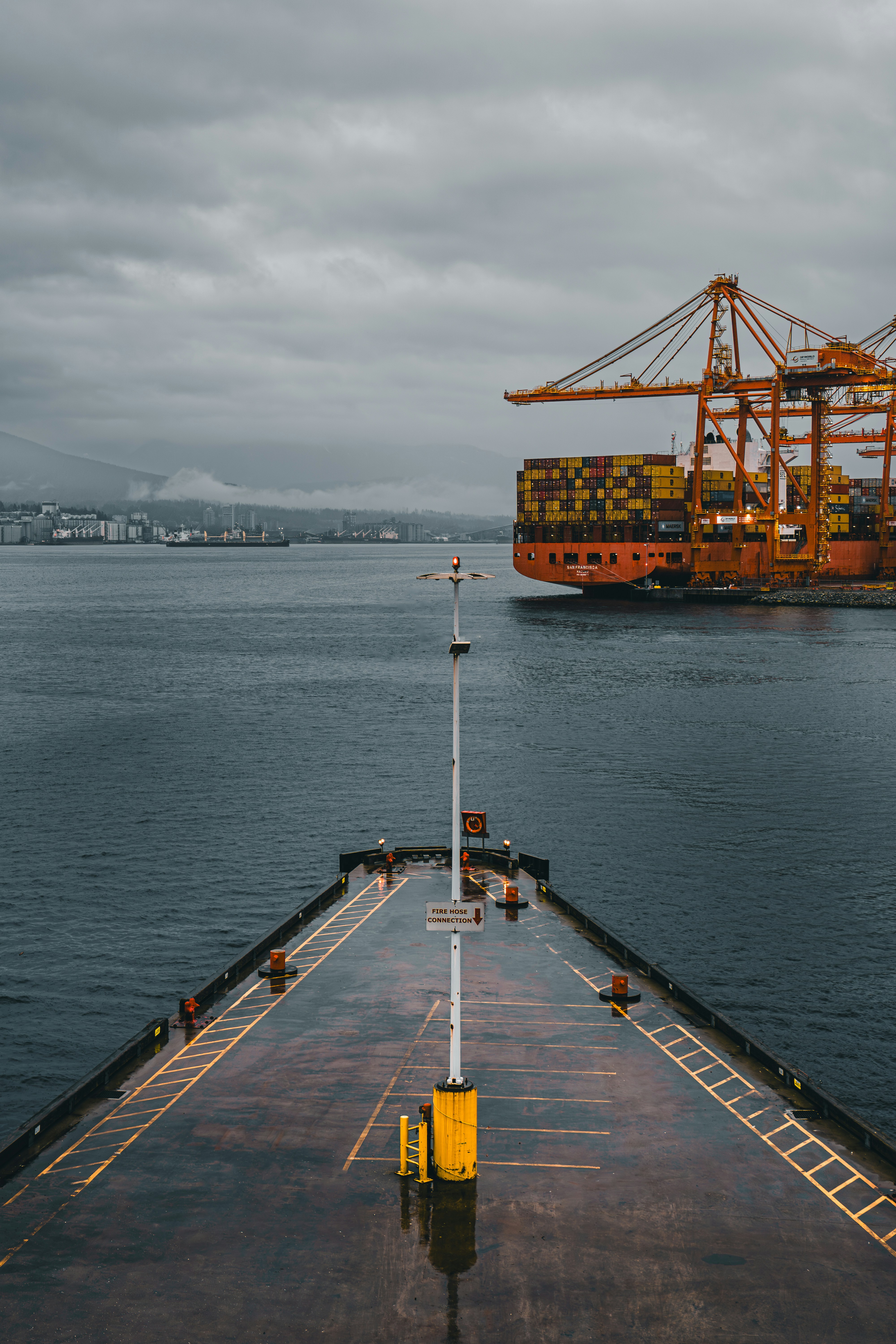 A dock with a large container ship in the background photo – Free ...