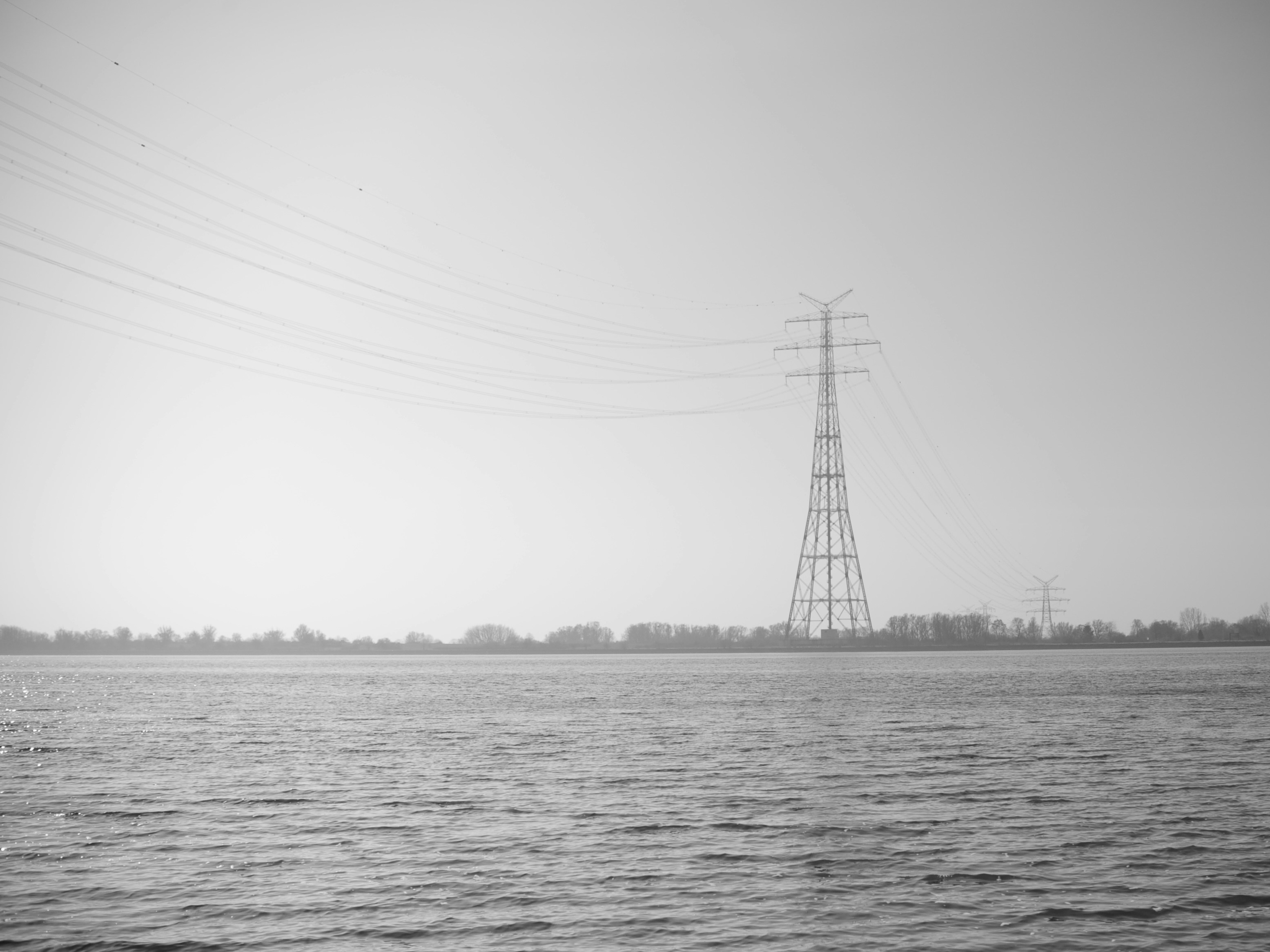 Monochrome Horizon: The Transmission Tower Over Gentle Waters