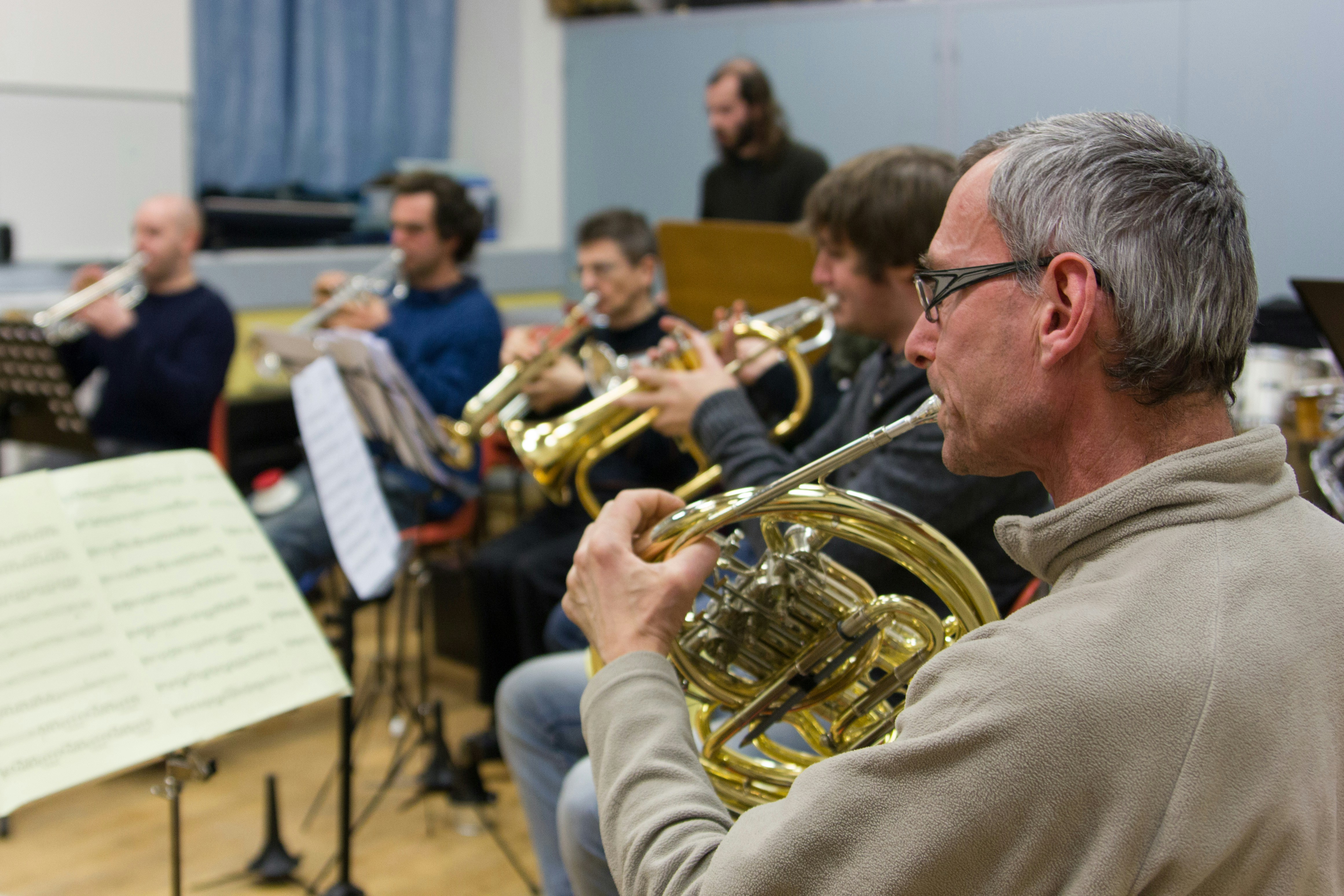 A group of men playing musical instruments in a room photo – Free Brass ...