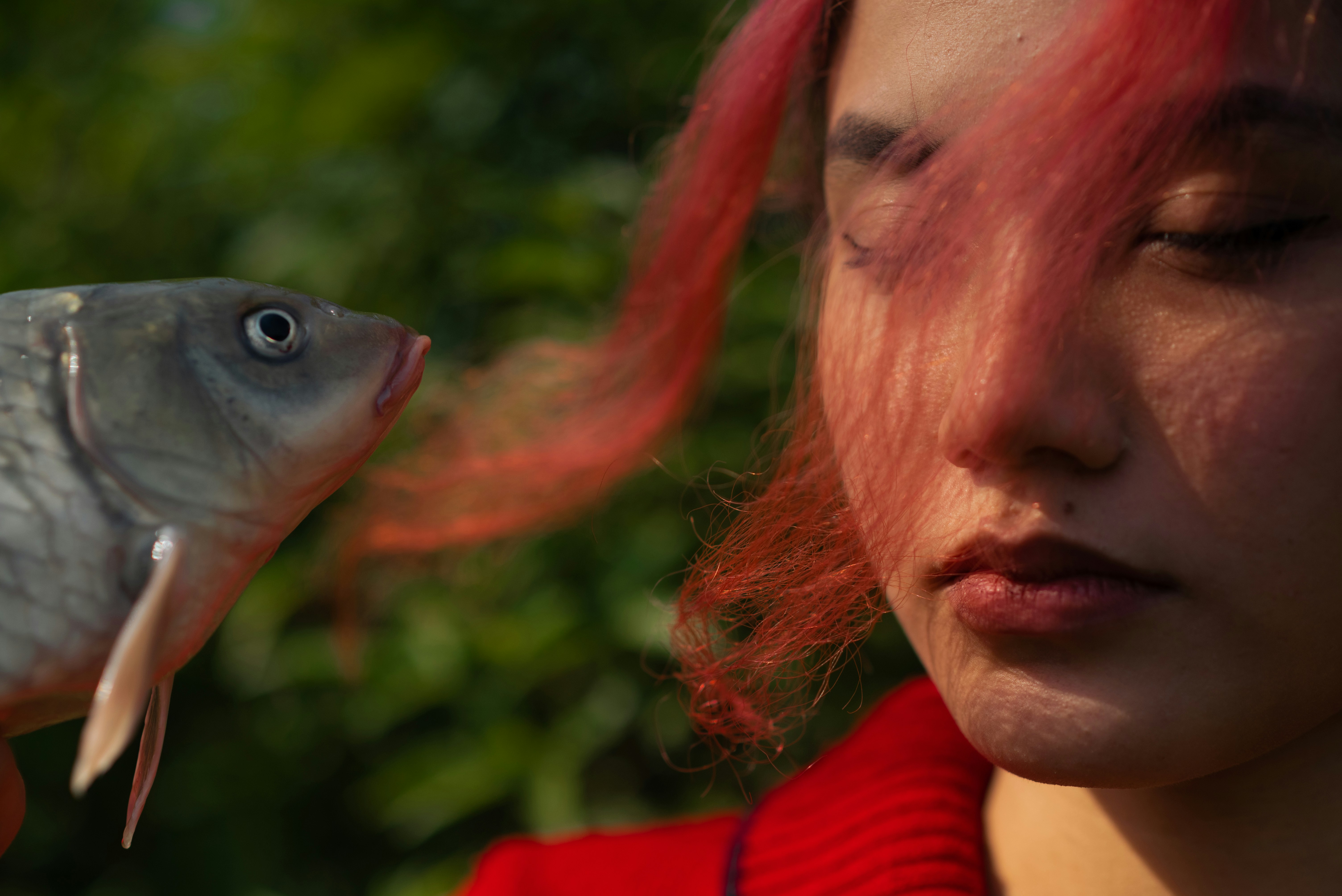 Red-Haired Pause: Eye-to-Eye Moment with a Silver Fish