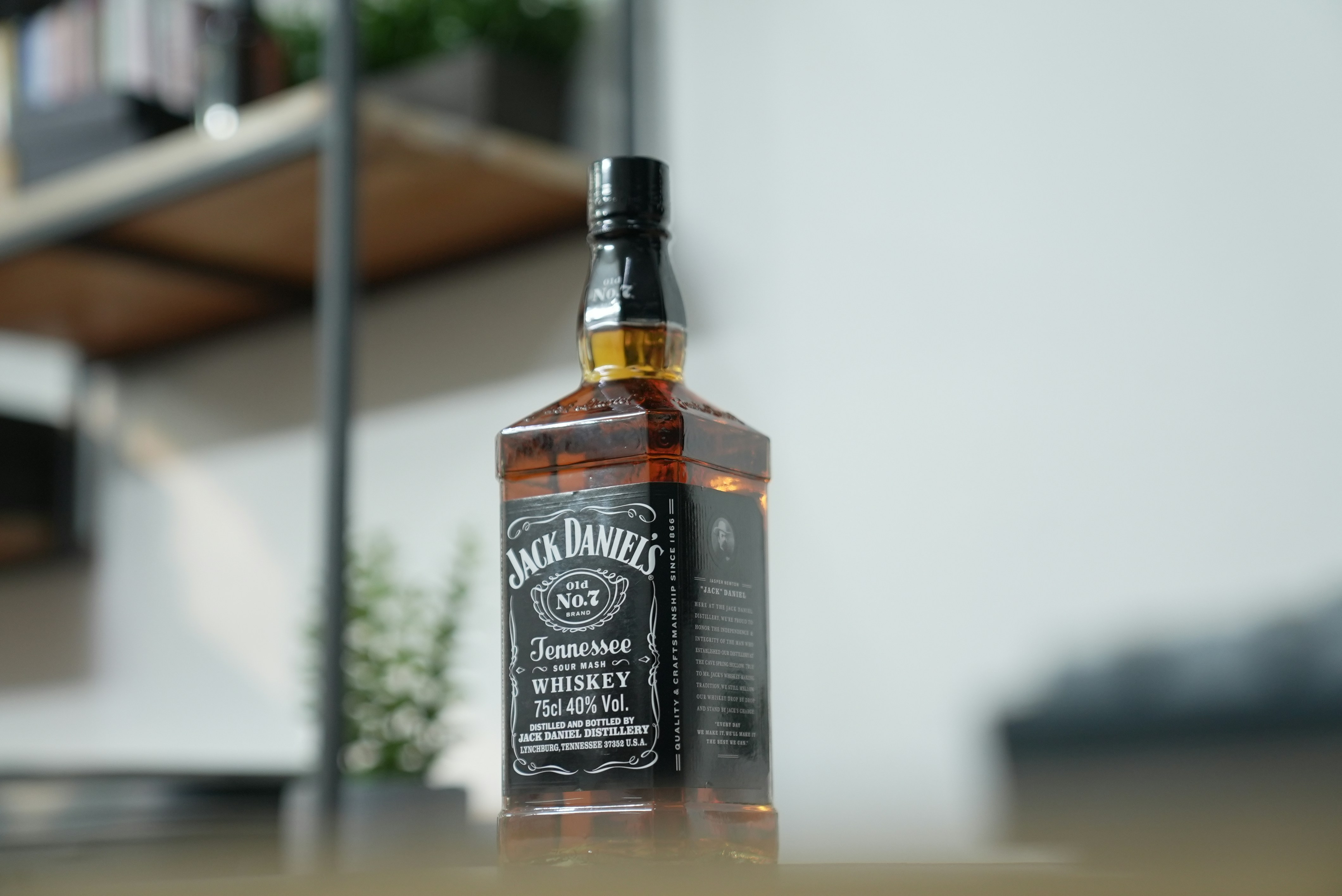 Jack Daniel's Tennessee whiskey bottle prominently displayed against a softly blurred background, highlighting its rich amber color and iconic label.