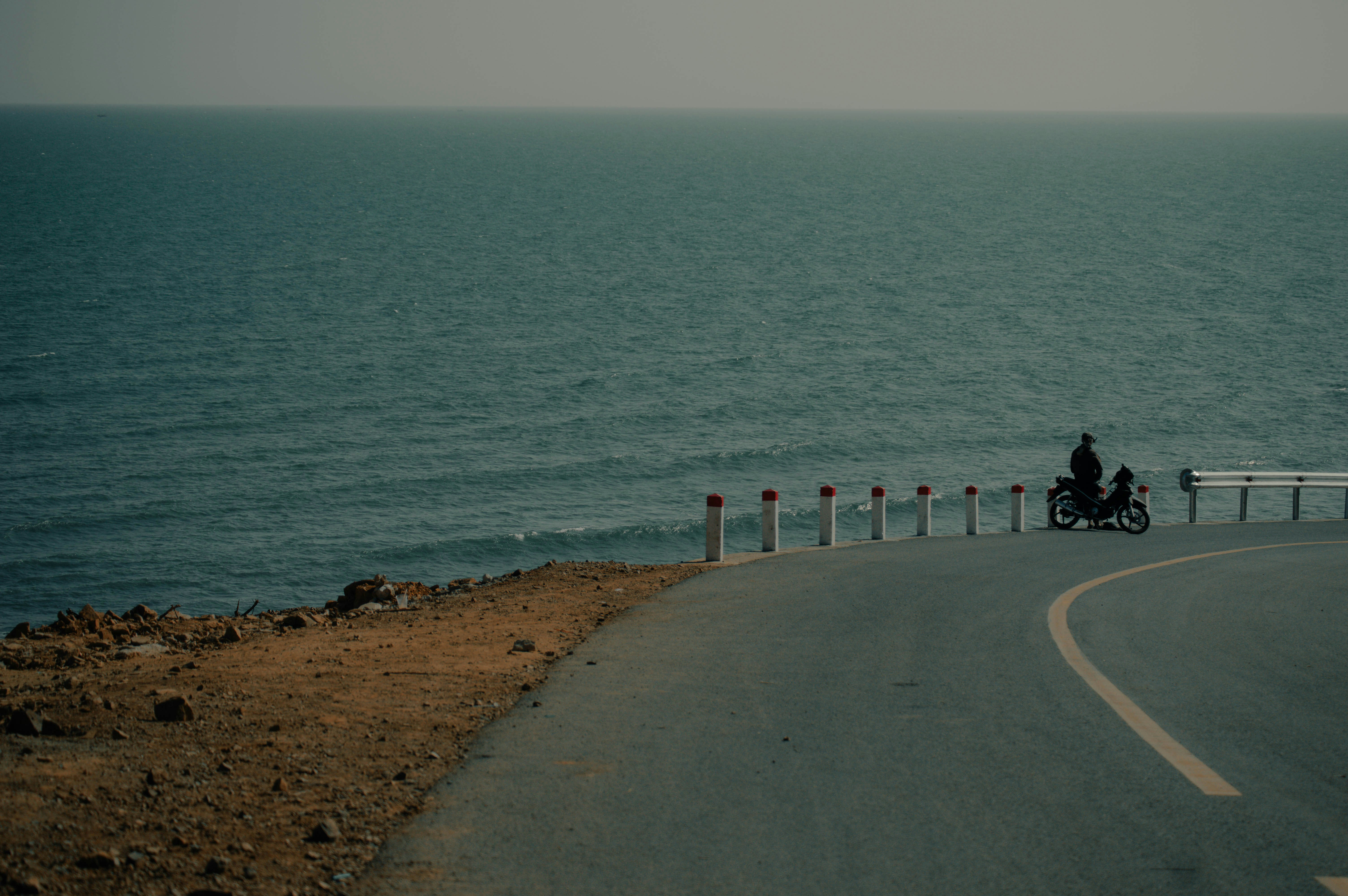 Coastal Curve: A solitary rider at the sea's edge