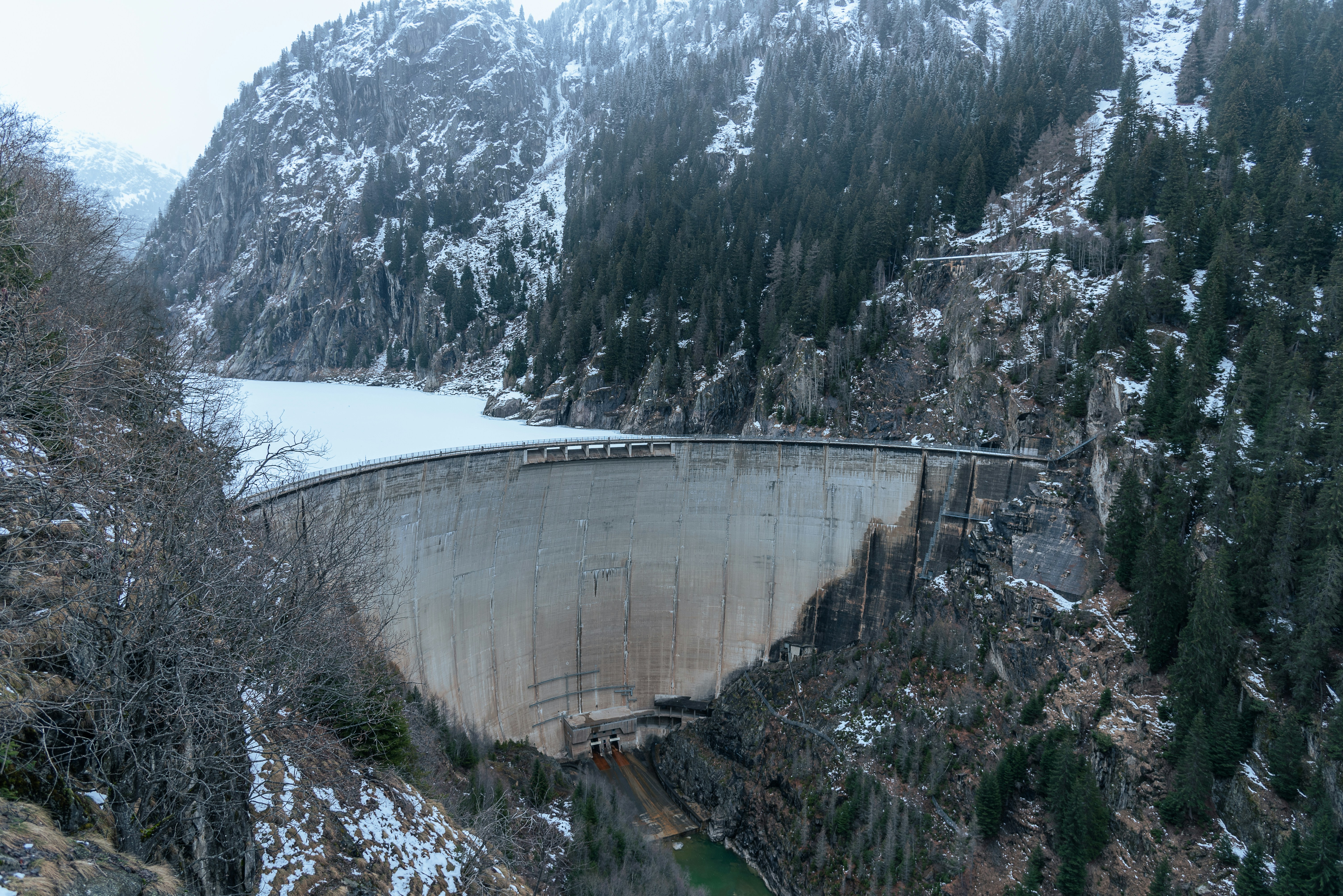 Winter Arc: Snow-Wrapped Dam Guarding a Quiet Valley