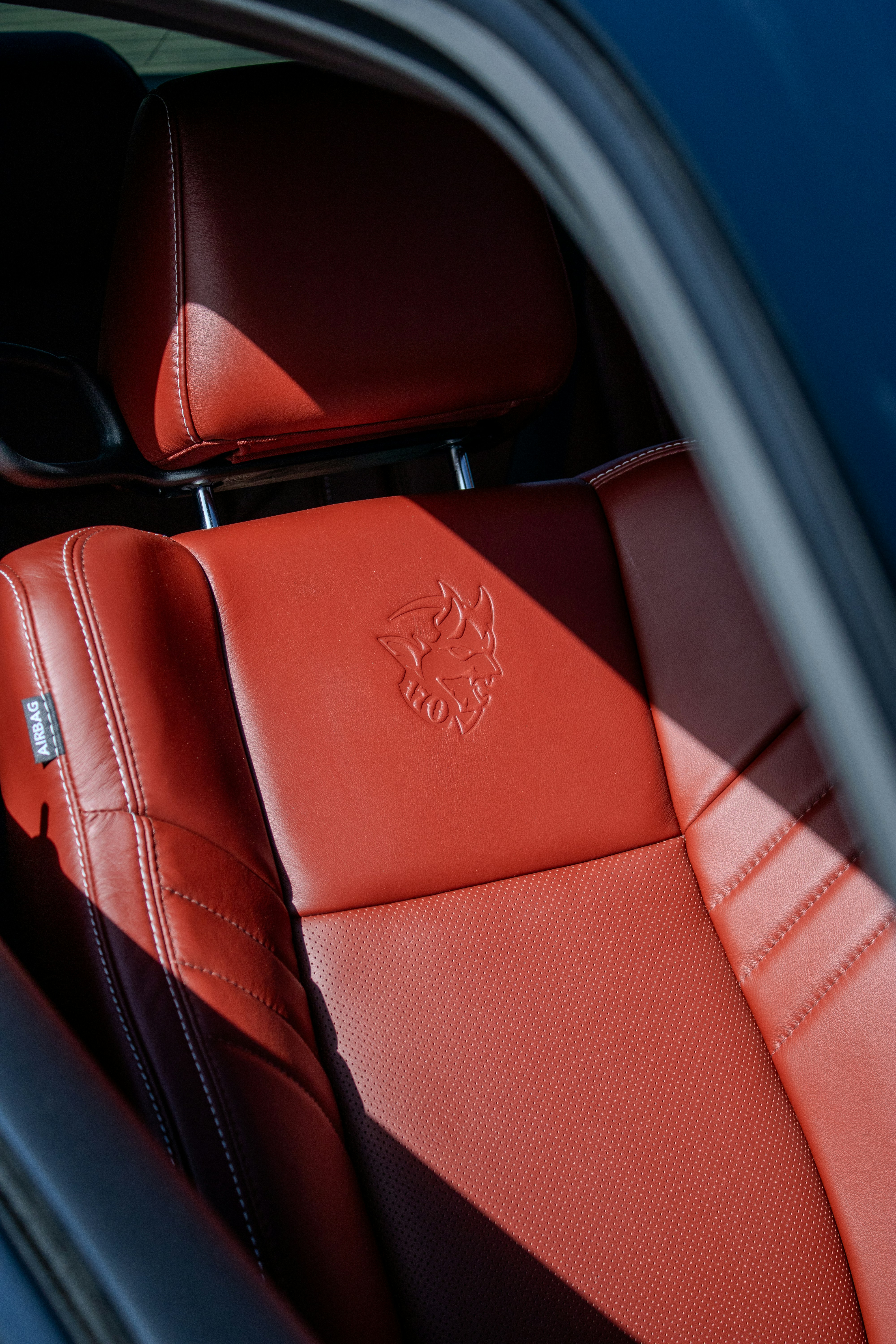 Red stitched sanctuary: a car seat’s bold interior glow