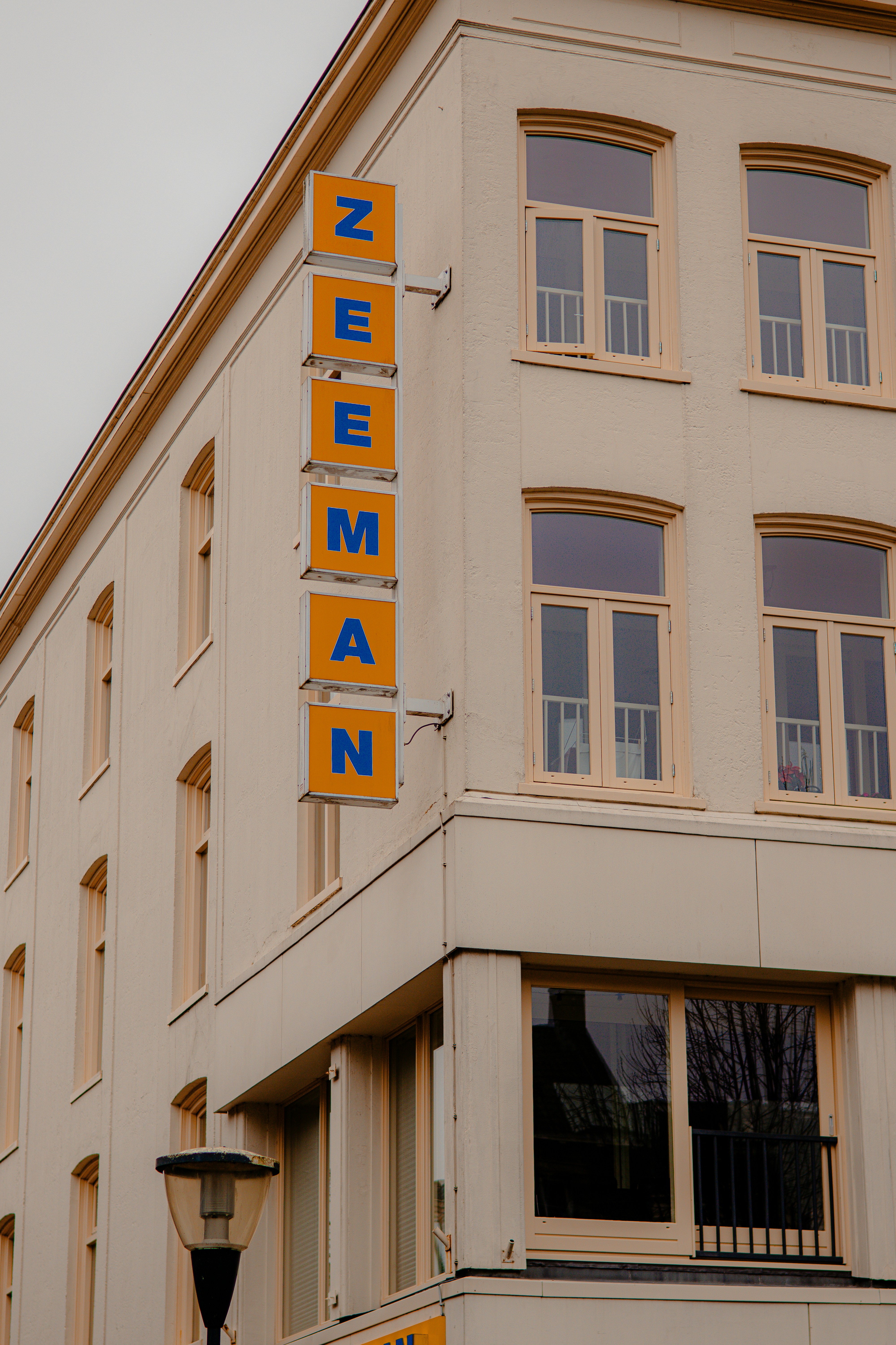 Vertical Signage on a Cornered Building: ZEEMAN in Bold Orange