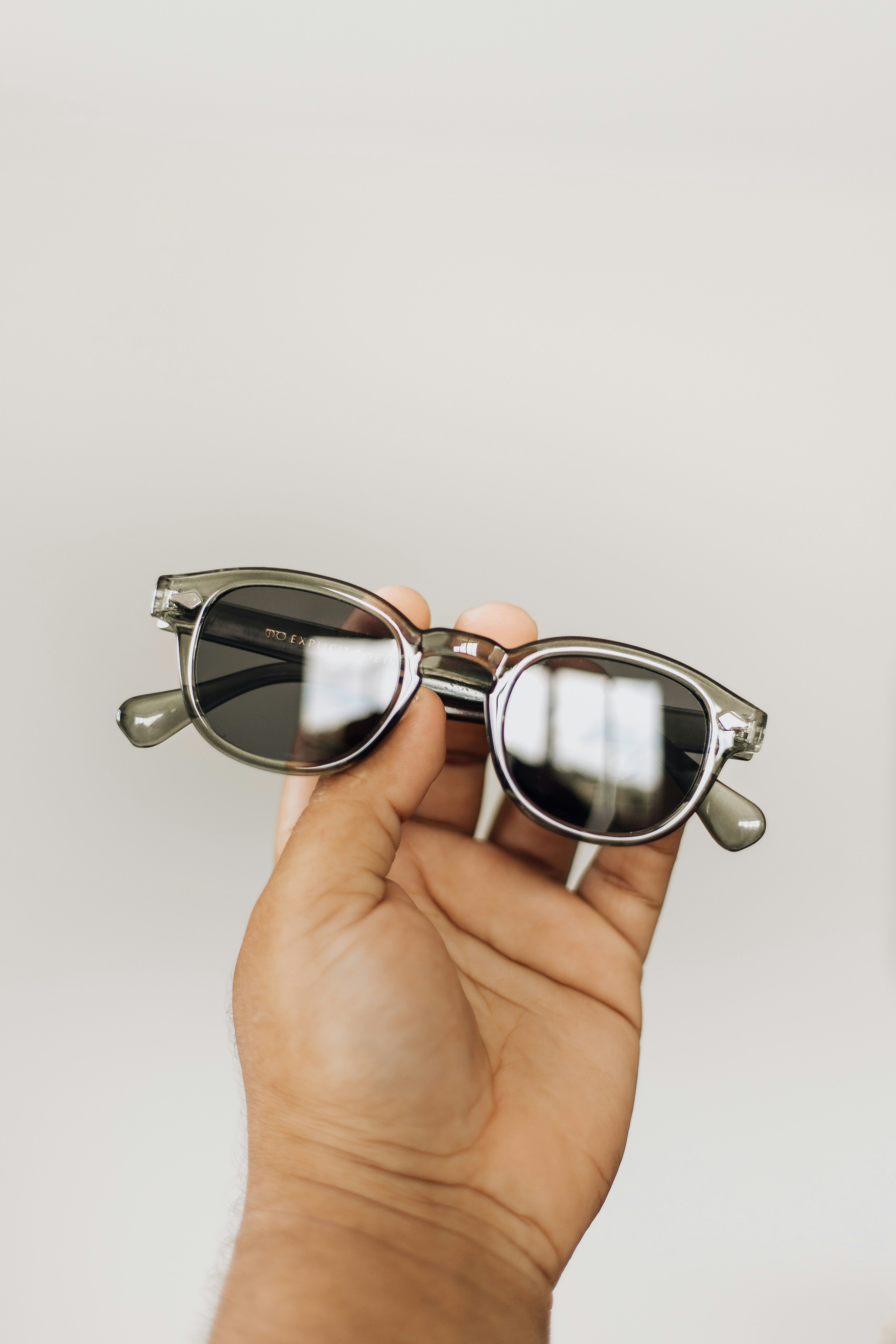 Glassy Gaze: Handheld Round Sunglasses in Soft Light