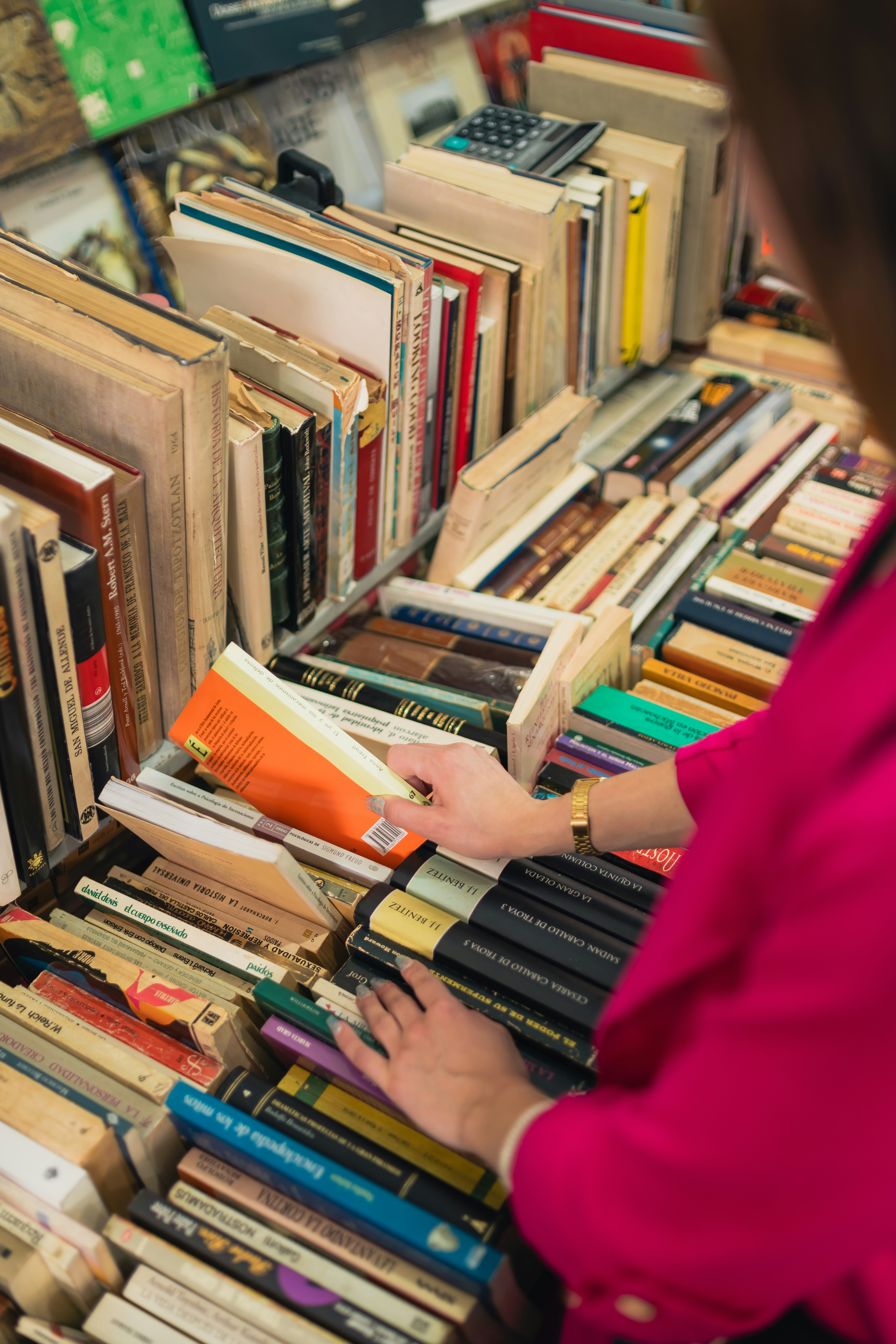 A woman is picking up a book from a bookcase photo – Free Book Image on ...
