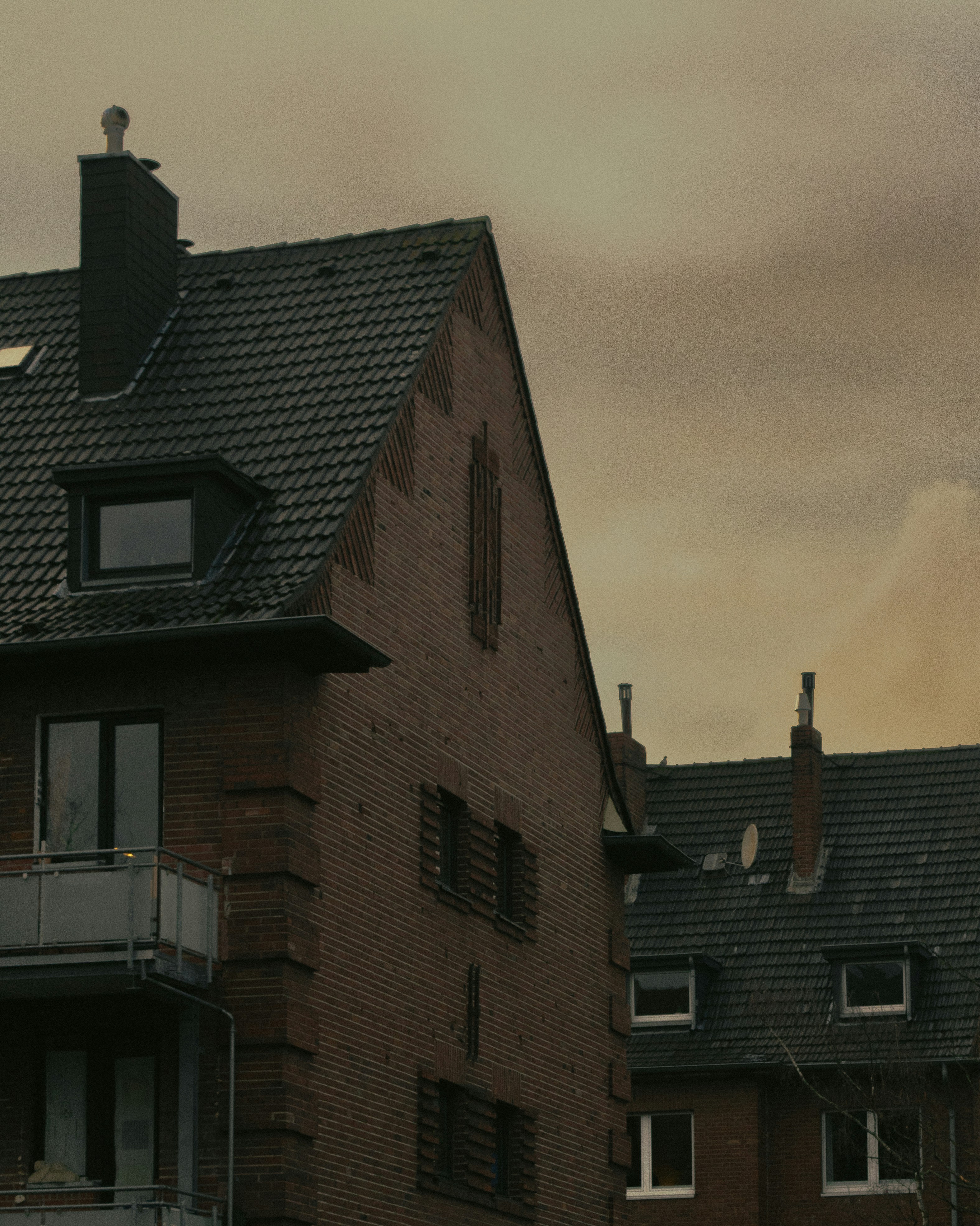 Dusk on the Gable: Quiet Brick Facades Under a Sepia Sky