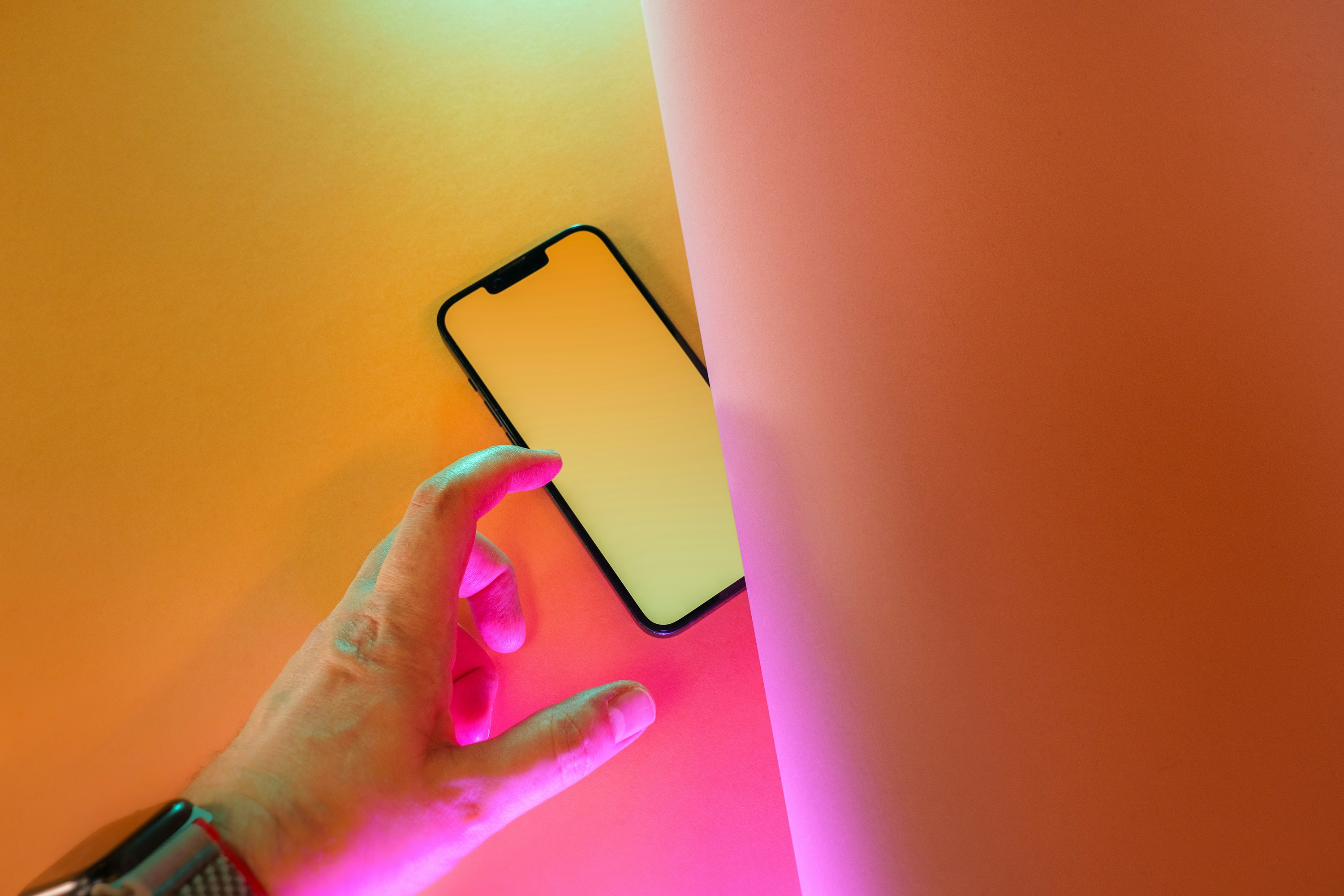 Neon-glow Touch: A Hand Reaches for a smartphone Amid Colorful Surfaces