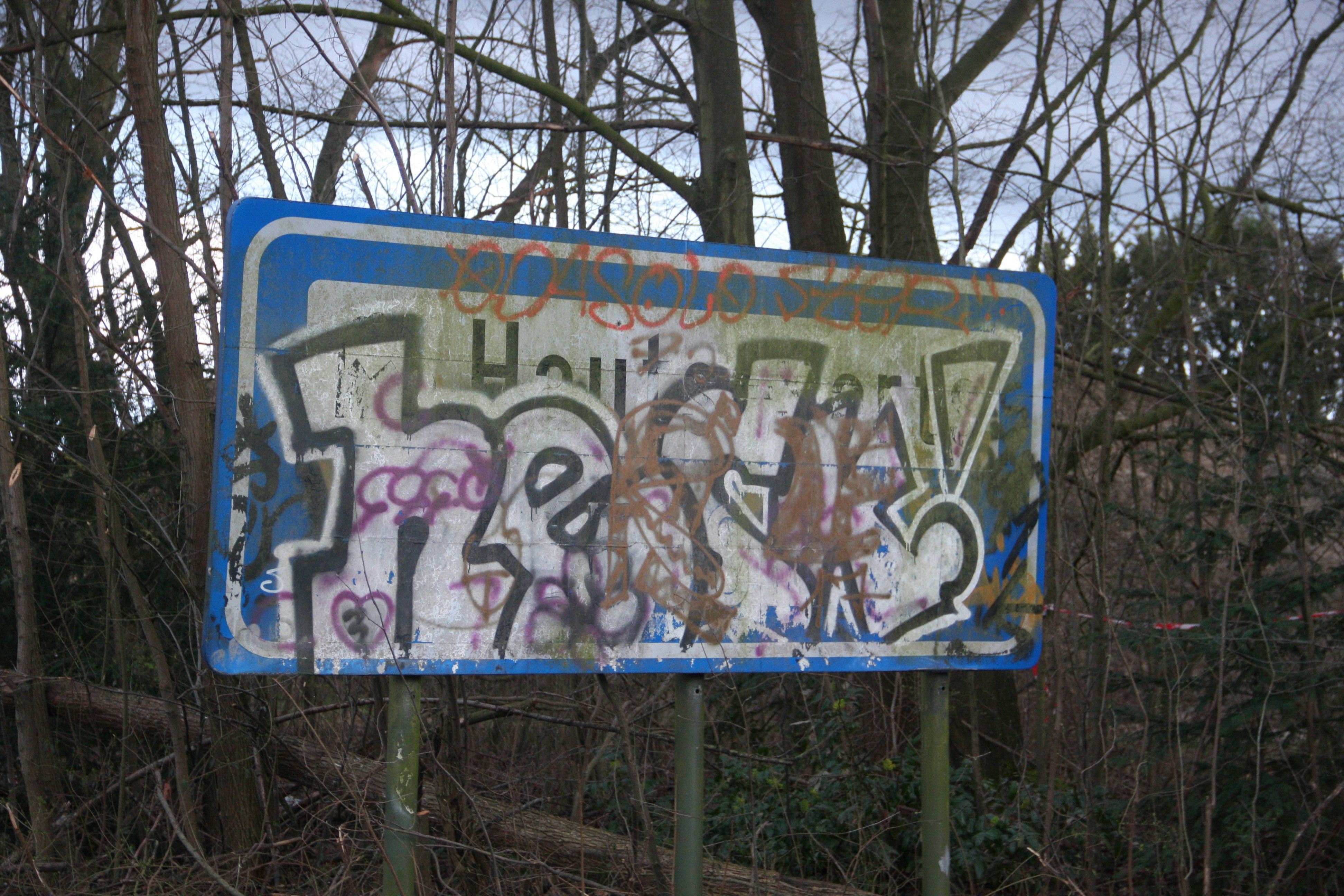 A blue and white street sign covered in graffiti photo – Free Grey ...