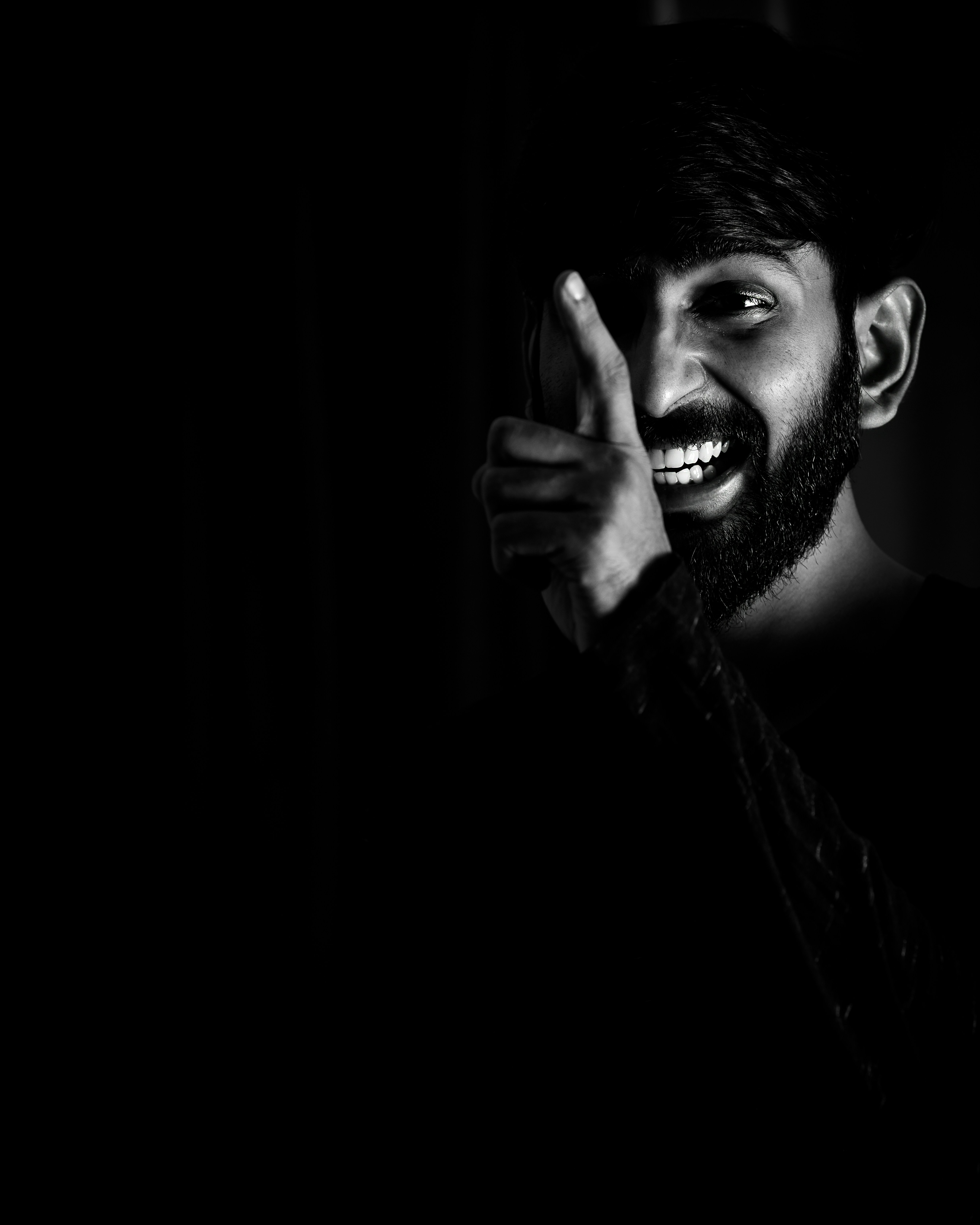 Half-Lit Grin: A Shadowed Portrait in Black and White